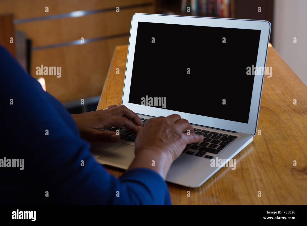 Mid-section of waitress using laptop in cafe Stock Photo - Alamy