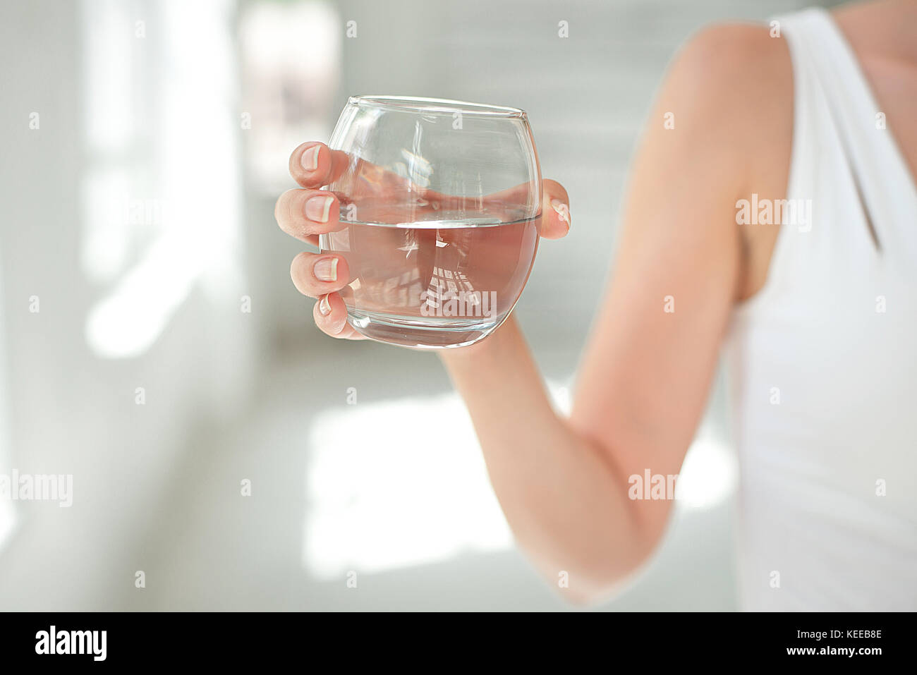 Female handa holding a clear glass of water. Slime body on background ...