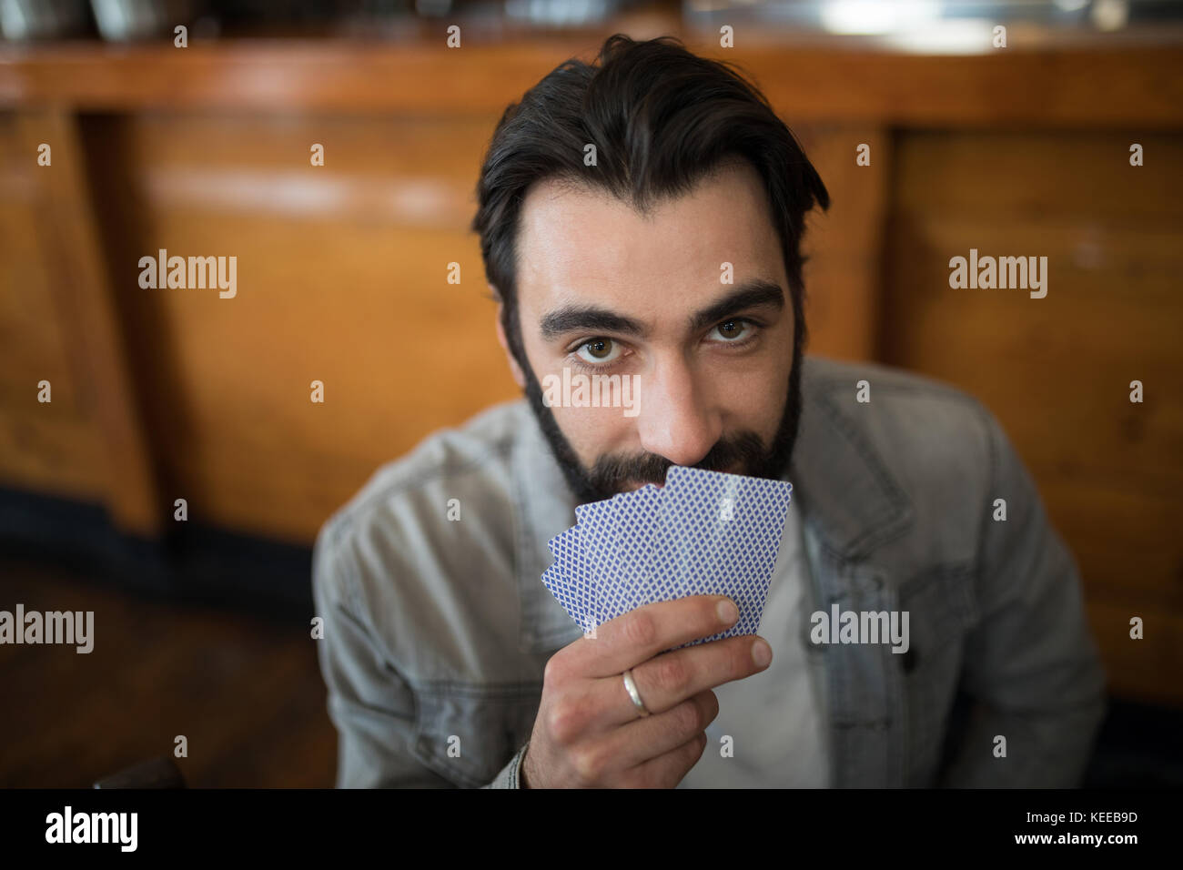 Young man holding playing card hi-res stock photography and images - Alamy