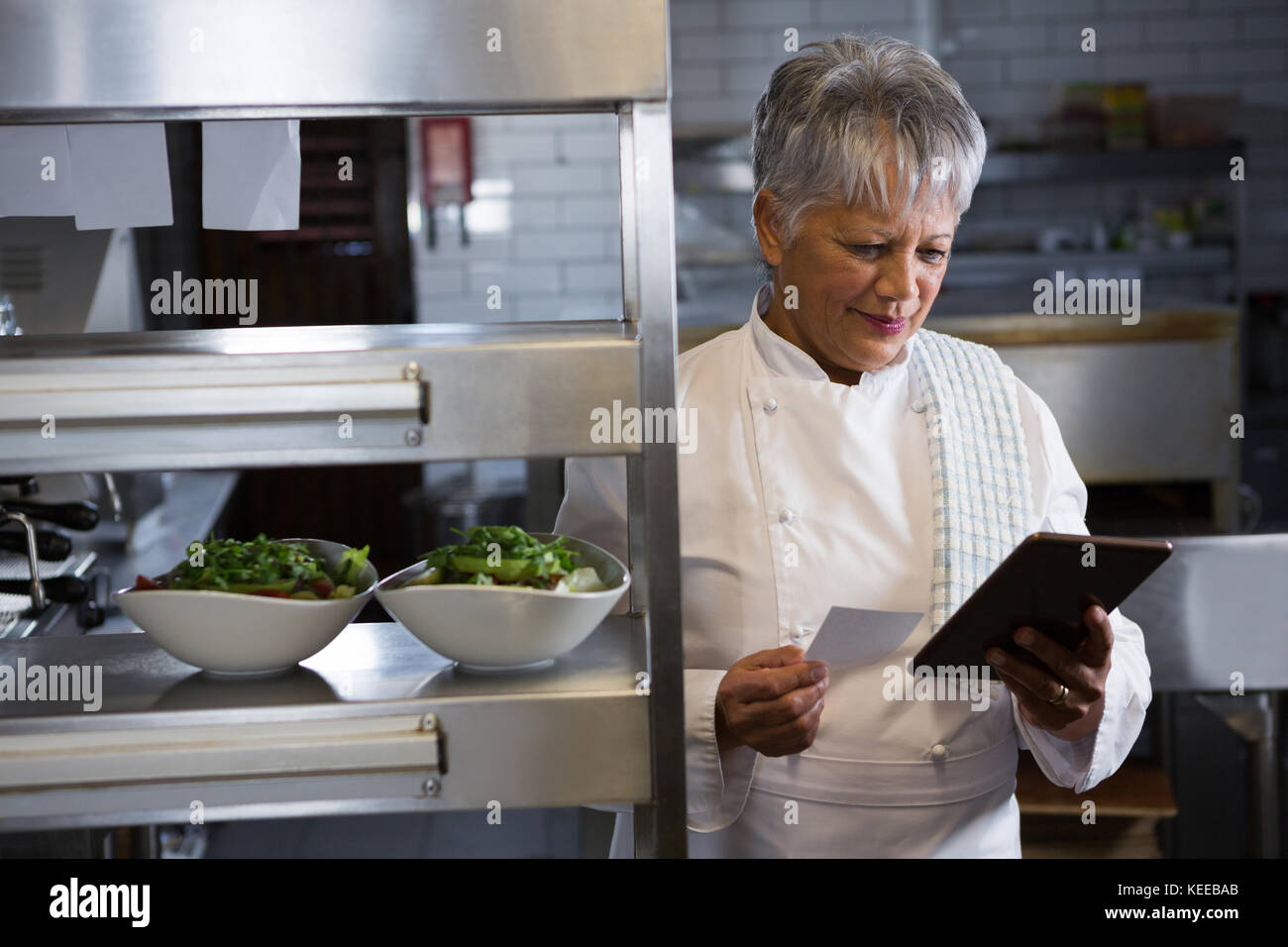 Female chef holding digital tablet in the kitchen Stock Photo - Alamy