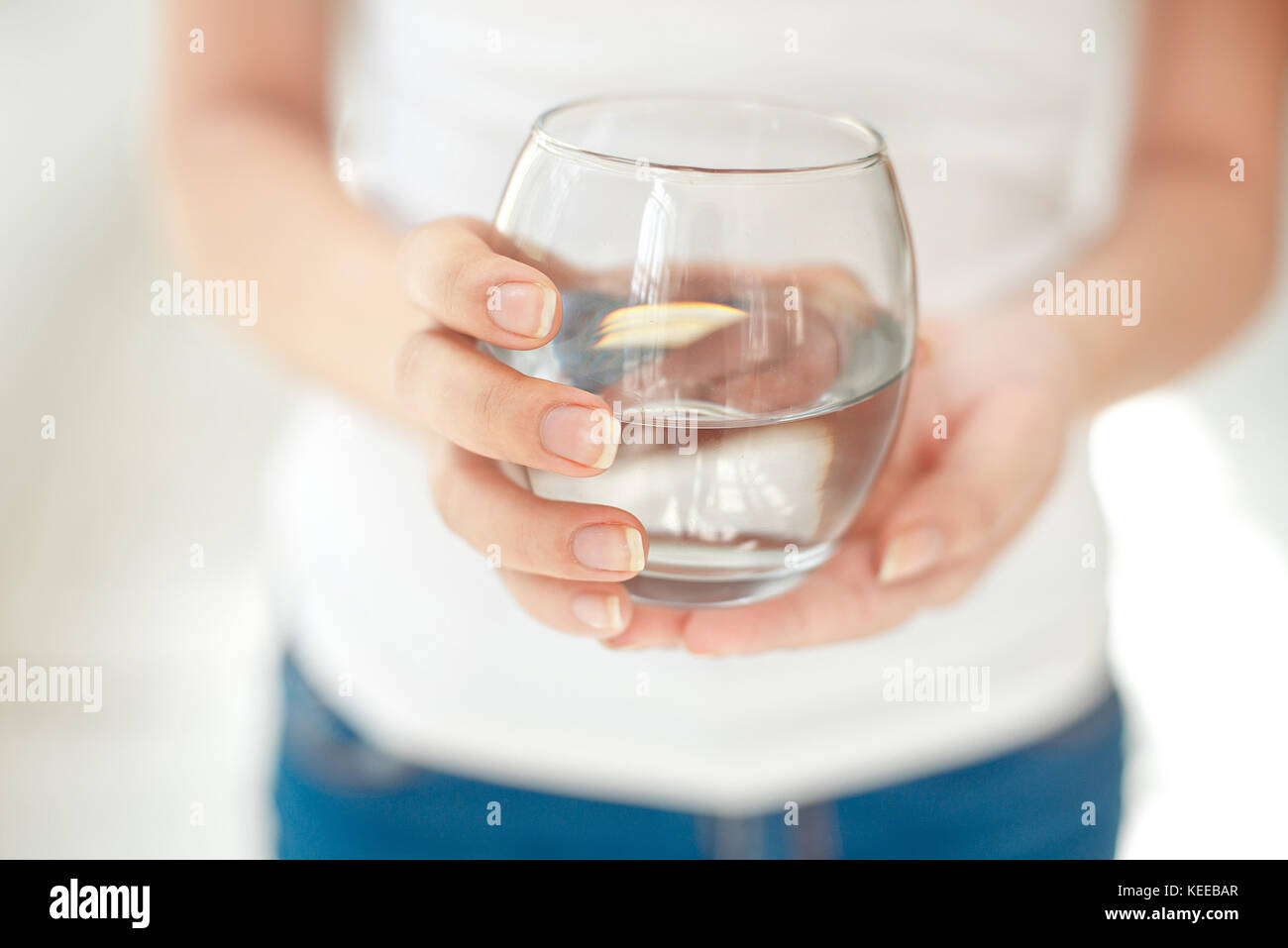 Female handa holding a clear glass of water. Slime body on background ...