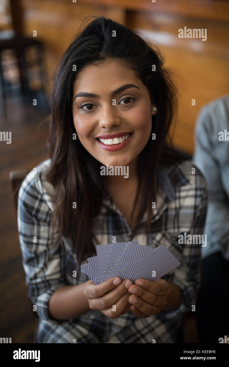 Portrait of smiling beautiful woman holding cards in bar Stock Photo ...