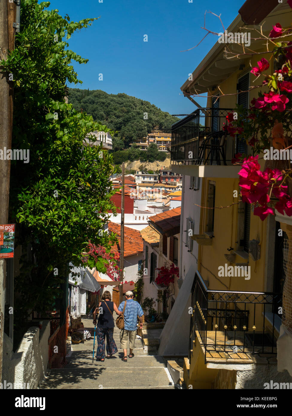 two people walk down the steep path from the castle to the town of ...