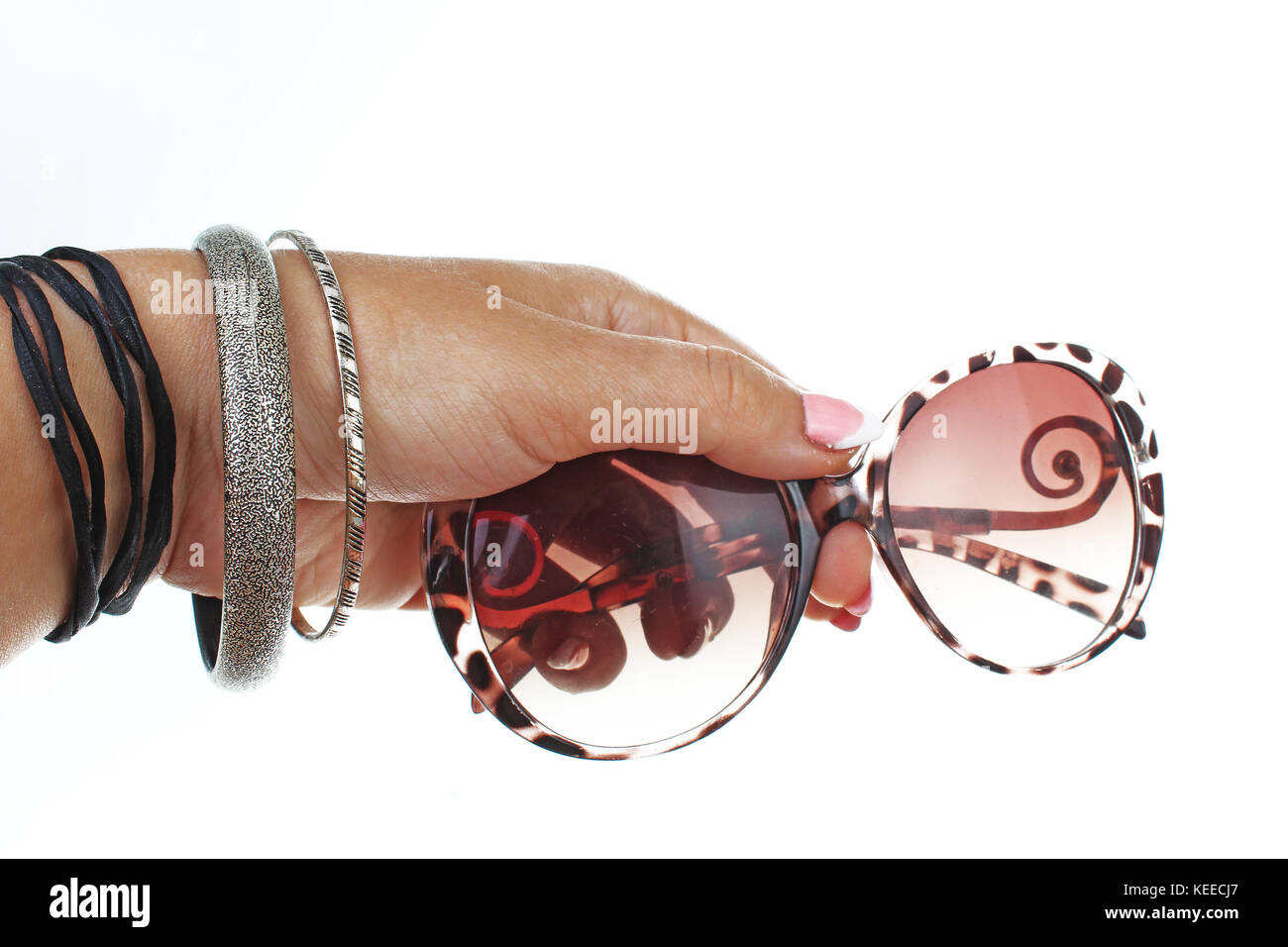 Woman hand holding sunglasses on isolated white cutout background ...