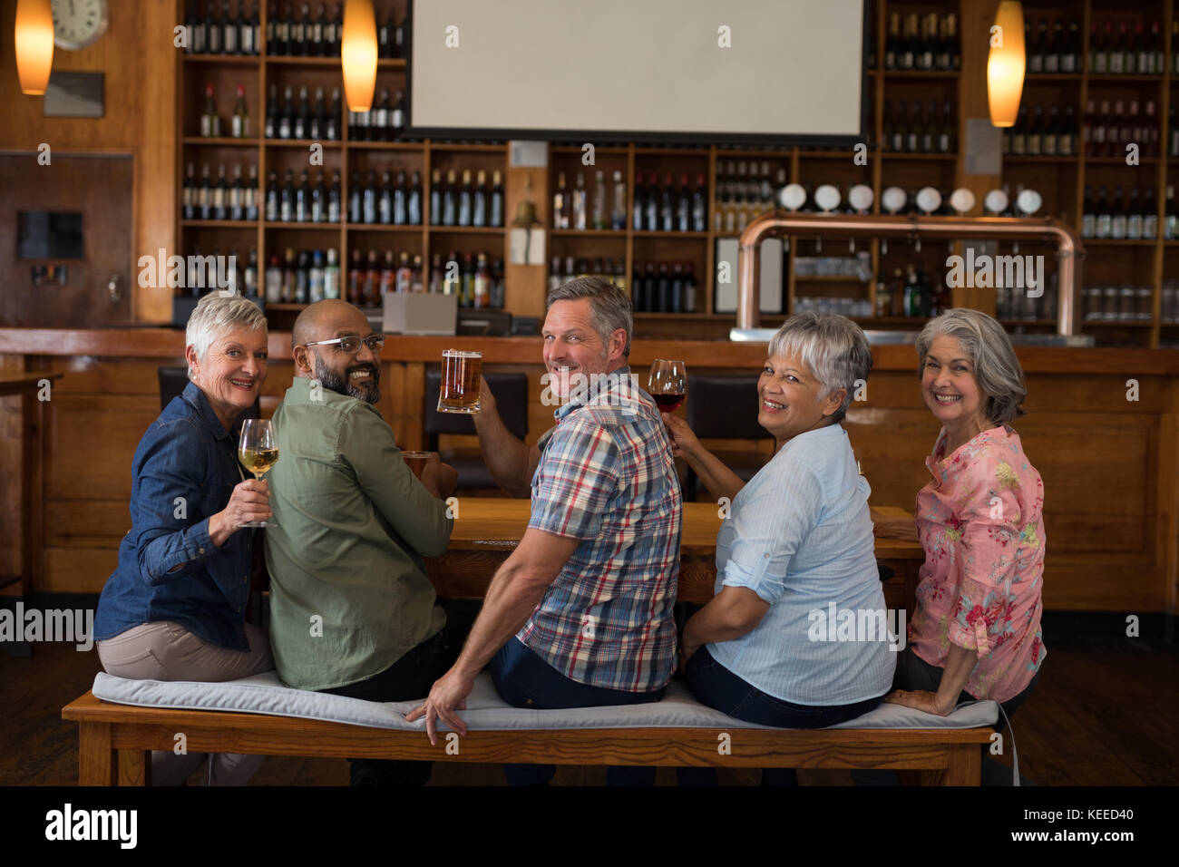 Portrait of happy friends having drinks together in bar Stock Photo - Alamy