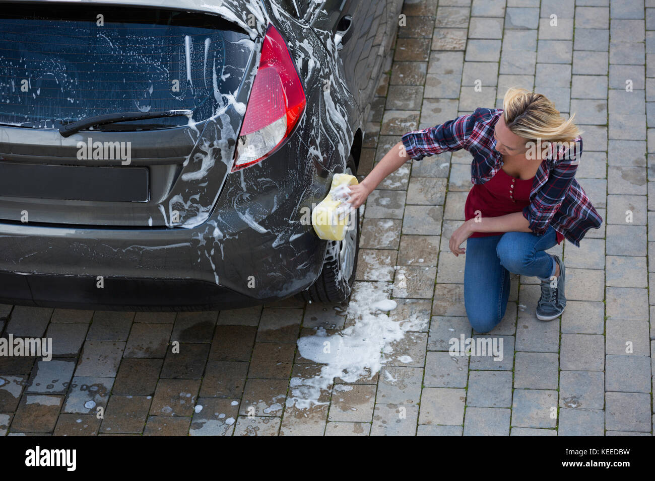 High angle view of woman cleaning her car with sponge Stock Photo - Alamy