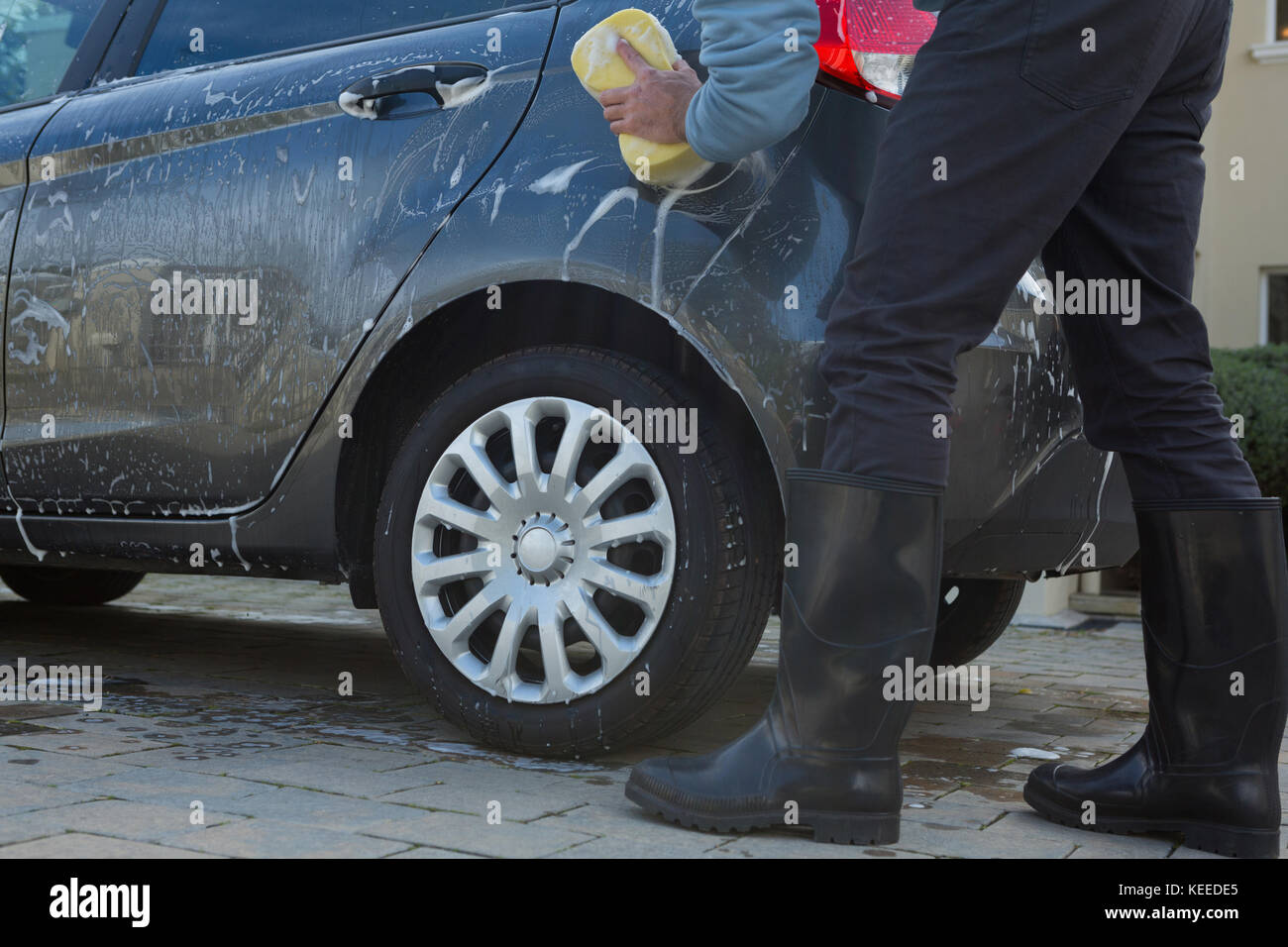 Male auto service staff washing a car with sponge Stock Photo - Alamy
