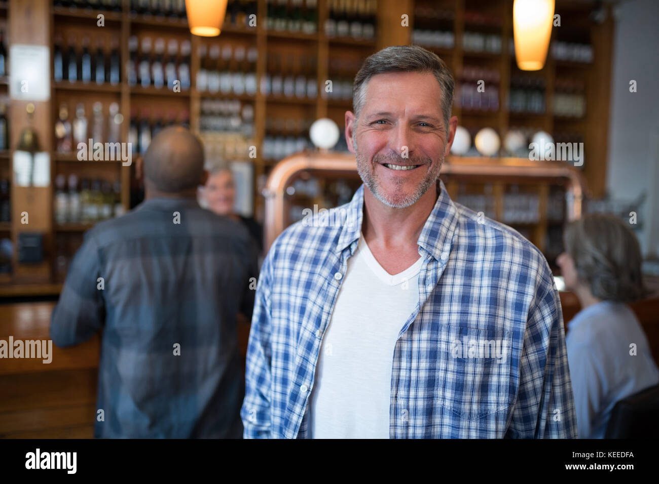 Portrait of happy man standing in bar Stock Photo - Alamy