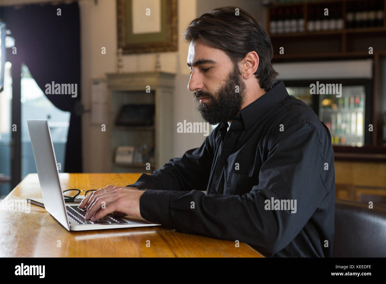 Man using laptop at bar Stock Photo - Alamy