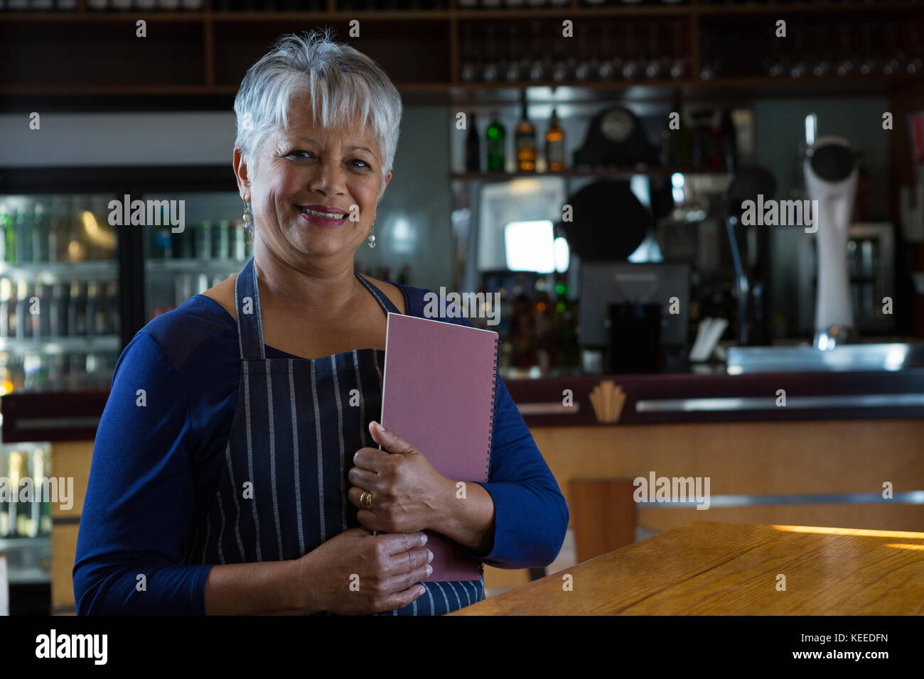 Waitress holding menu card at the bar Stock Photo - Alamy