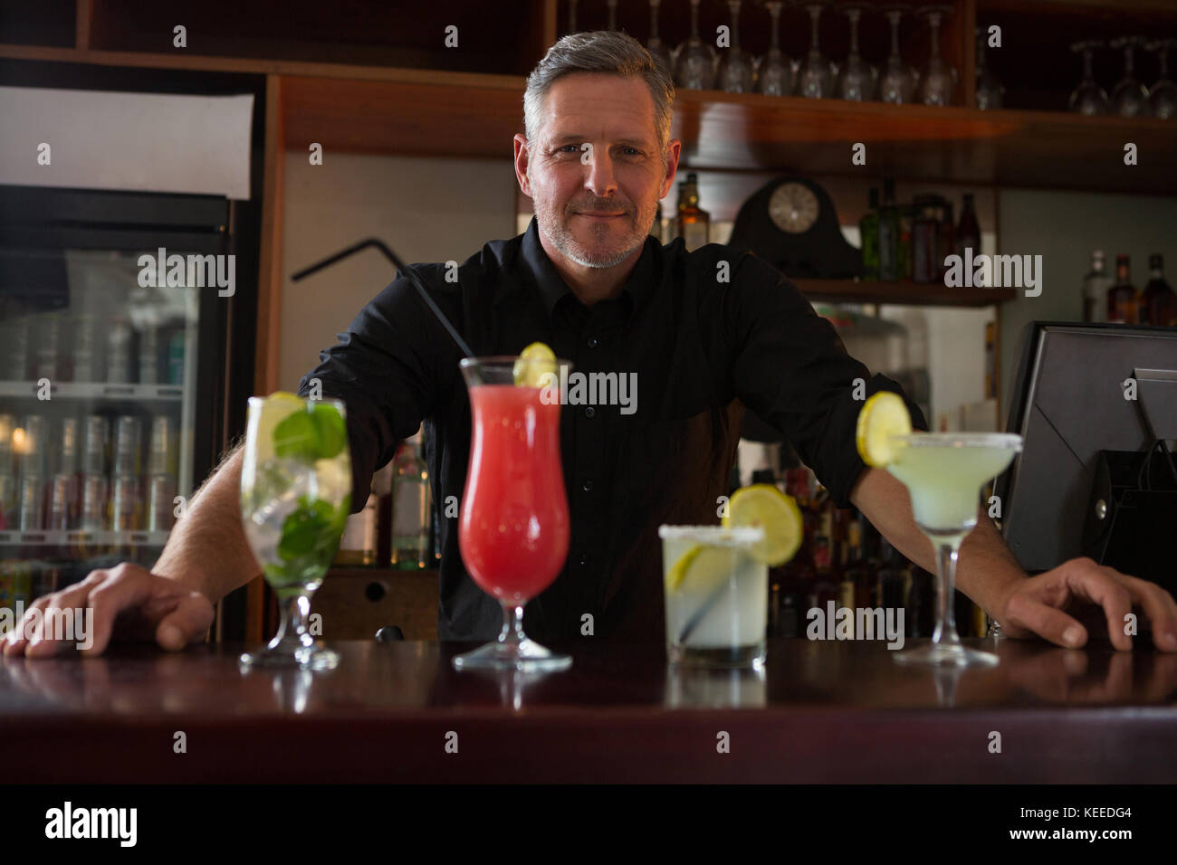 Portrait of waiter standing at bar counter Stock Photo - Alamy