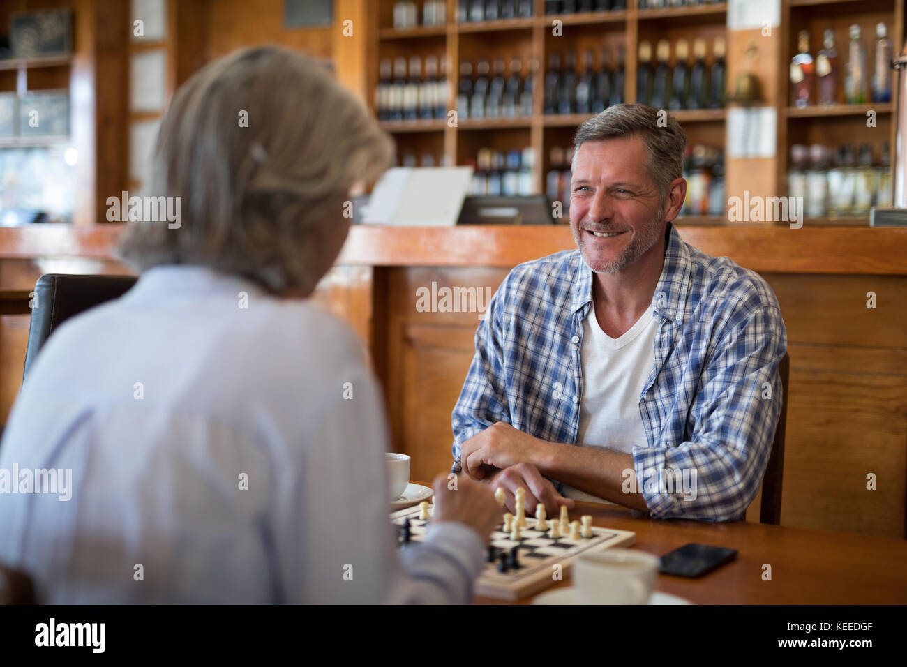 Happy friends playing chess in bar Stock Photo - Alamy