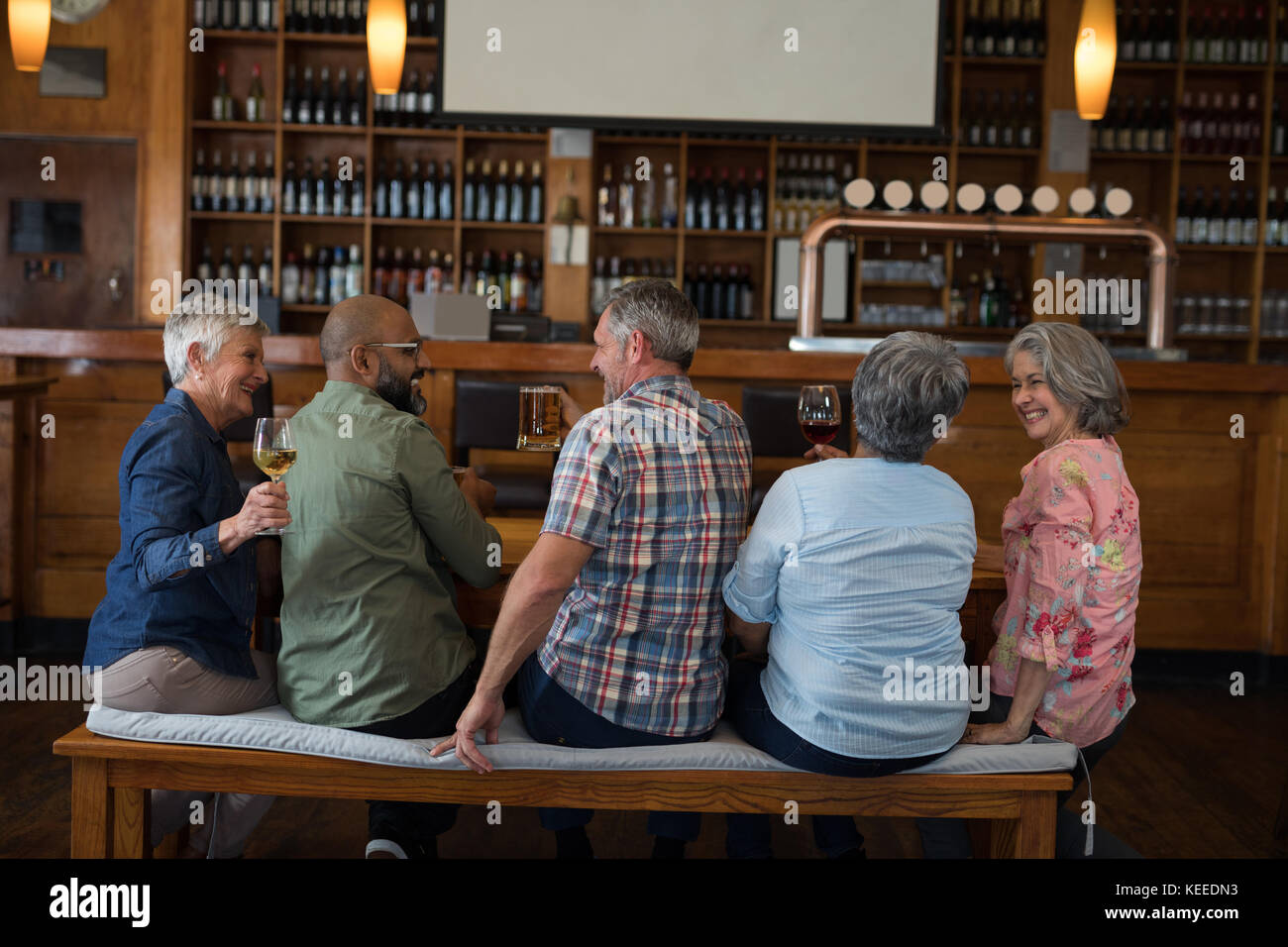 Happy friends having drinks together in bar Stock Photo - Alamy