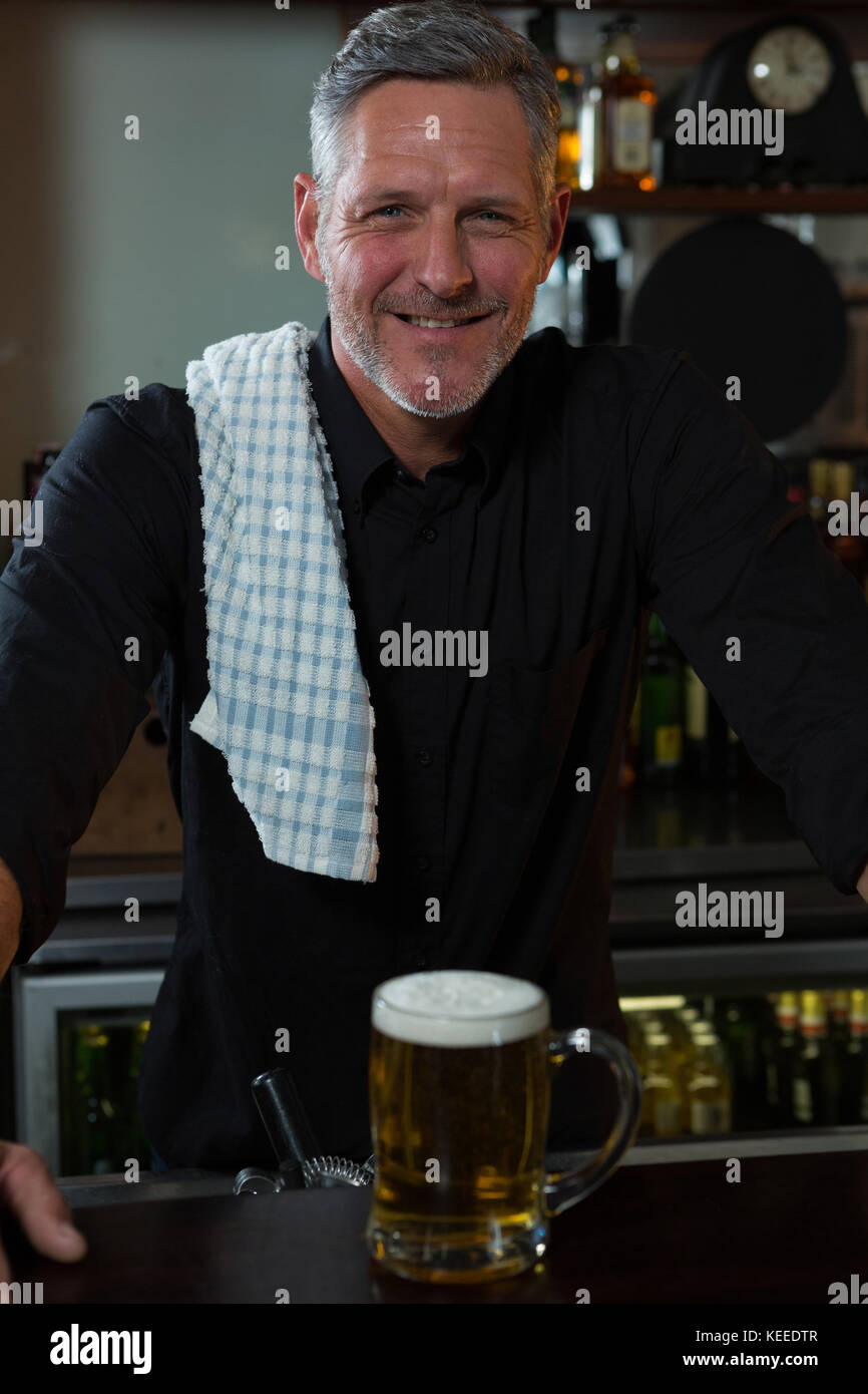 Portrait of happy bar tender leaning at bar counter Stock Photo - Alamy