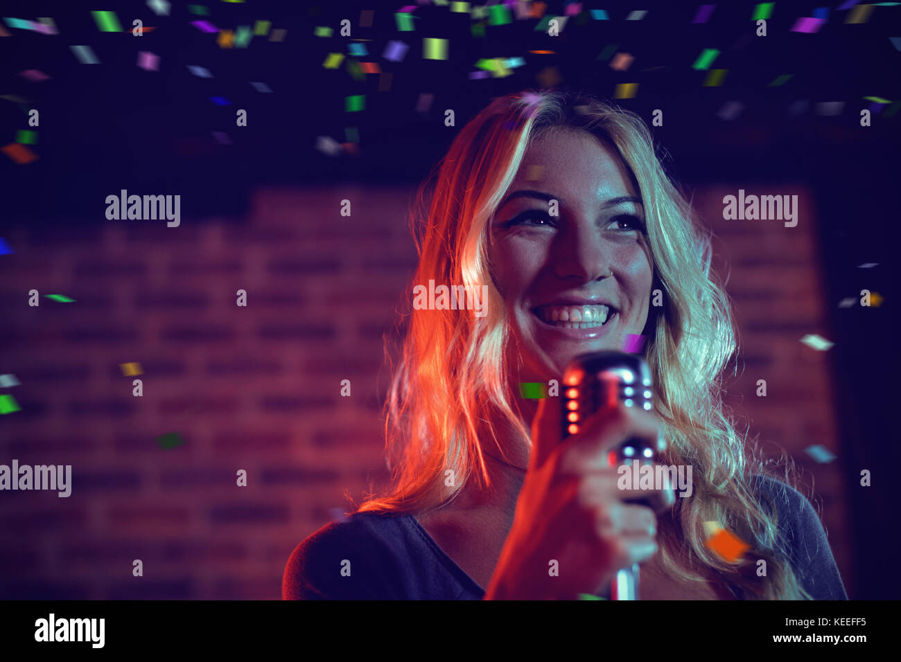 Flying colours against female singer performing at music concert Stock ...