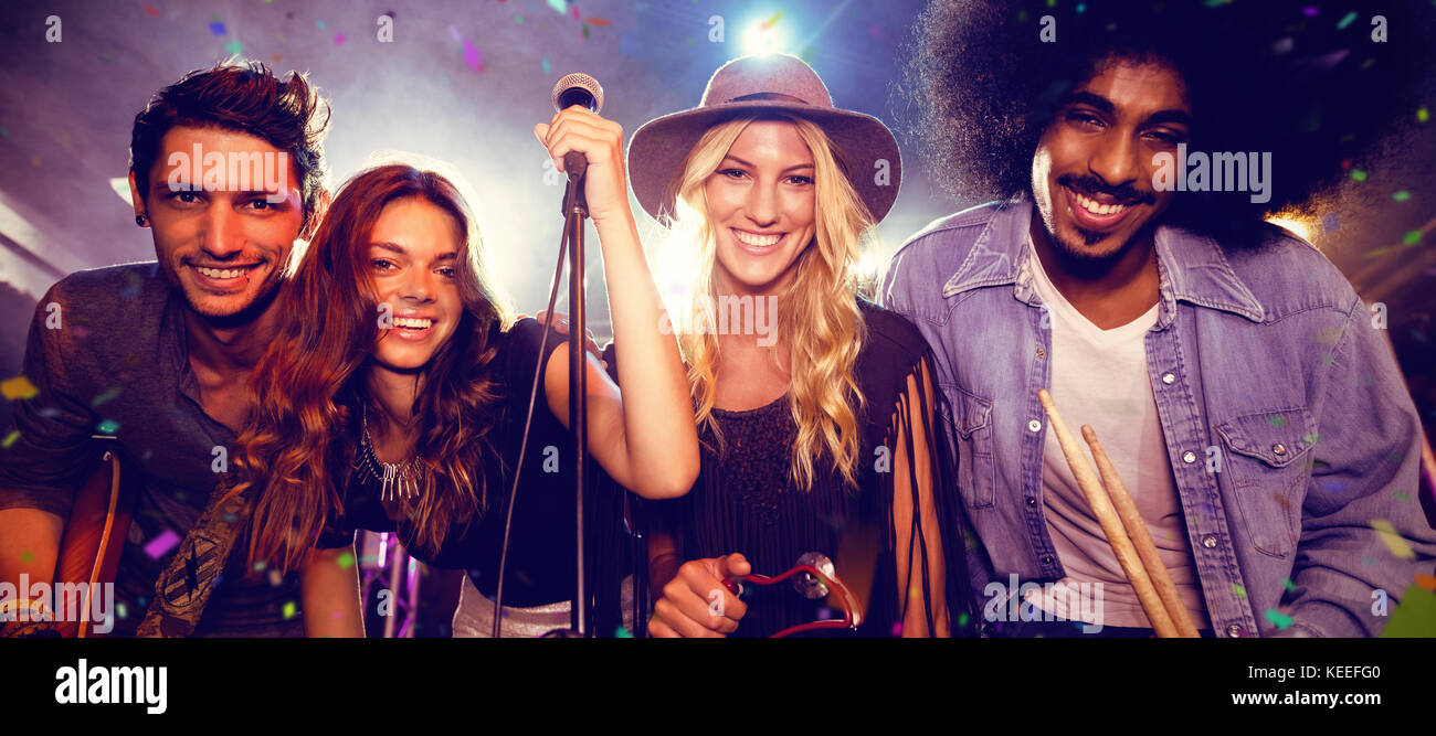 Flying colours against portrait of smiling musicians at nightclub Stock ...