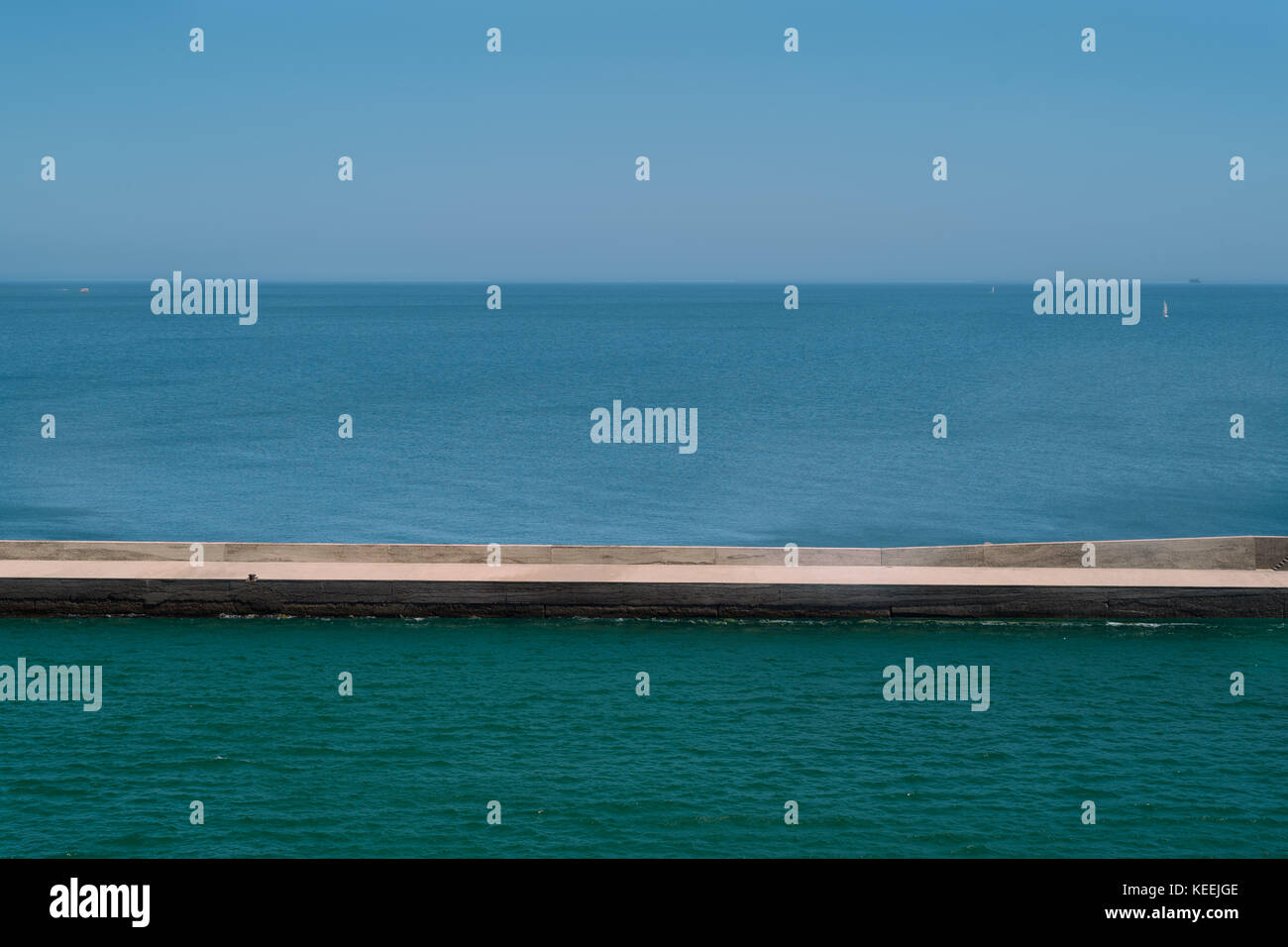 Harbour with different color sea's Stock Photo - Alamy