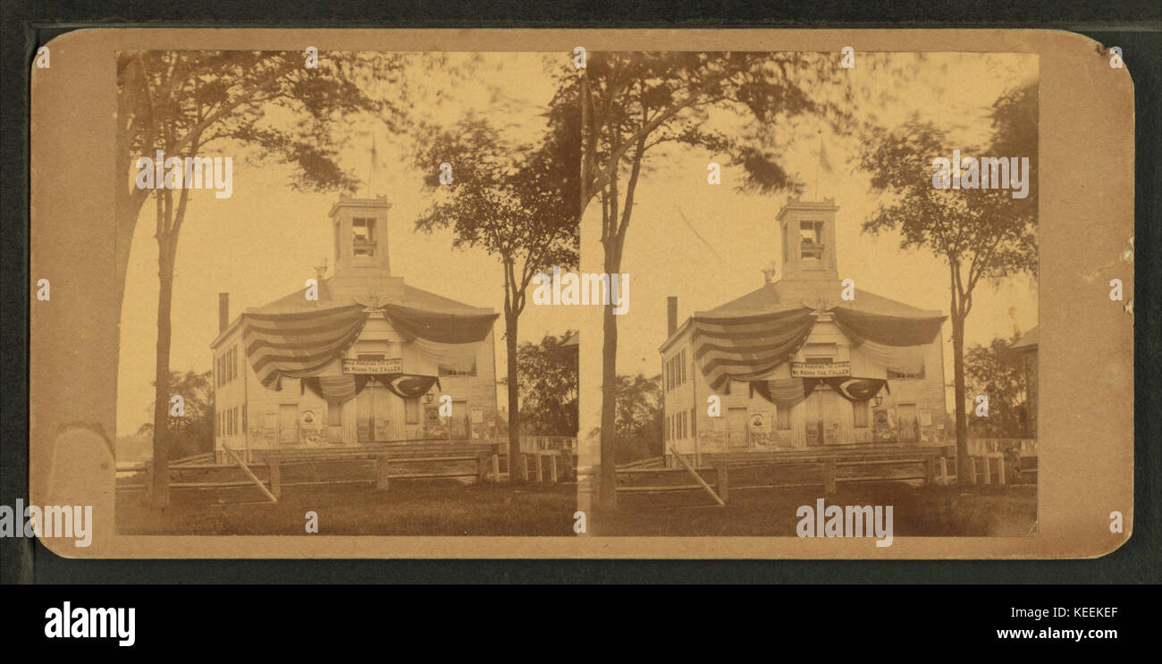 Building with bell tower draped with flags, bunting, sign reading While ...
