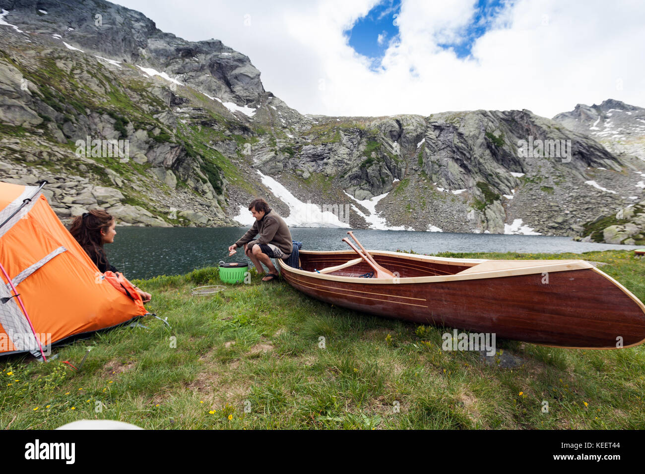 Couple on the lake shore with canoe, grilled meat Stock Photo - Alamy