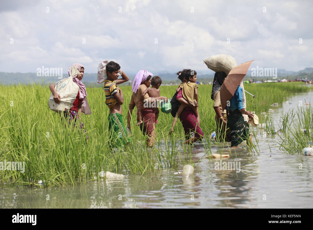 October 17, 2017 - Ukhiya, Bangladesh - Newly arrived Rohingya Muslims wade through water ...