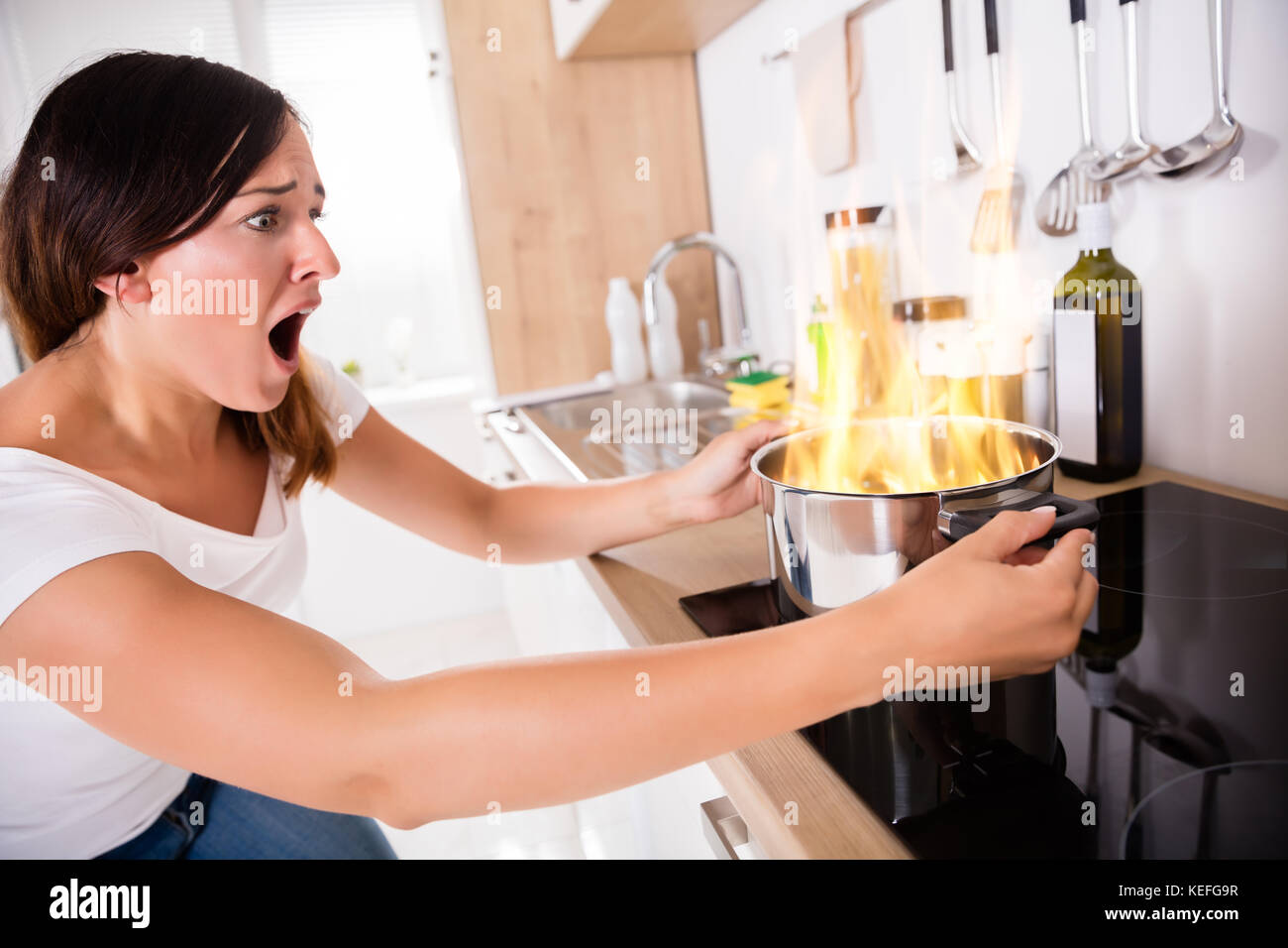 Shocked Young Woman Looking At Burnt Food In Cooking Pot Stock Photo ...