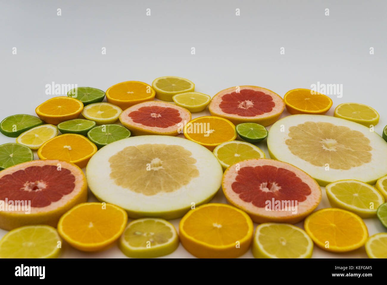 Slices of various citrus fruits on white background Stock Photo - Alamy