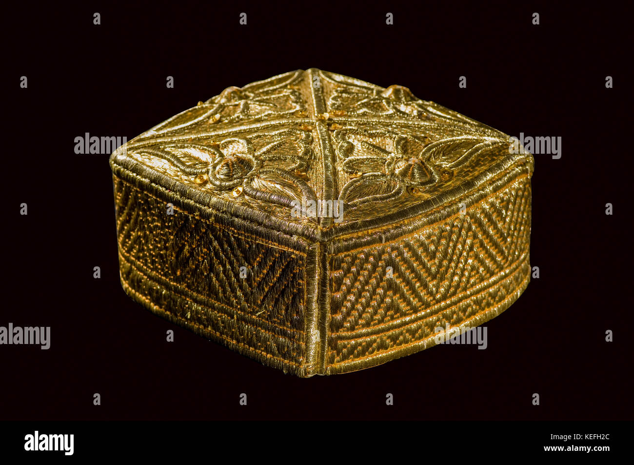 gold colored traditional asian skullcap cap on a black background Stock ...