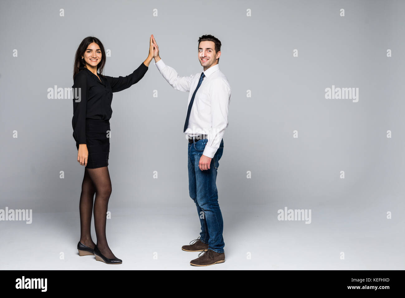 Enthusiastic business partners giving each other a high five Stock ...