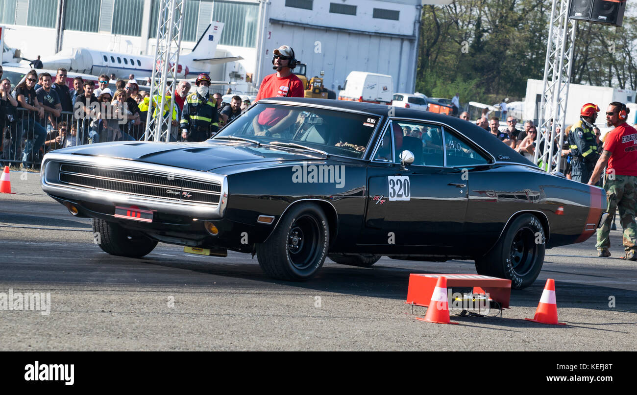 a classic mustang dragster car at a motor show competition speeding on ...