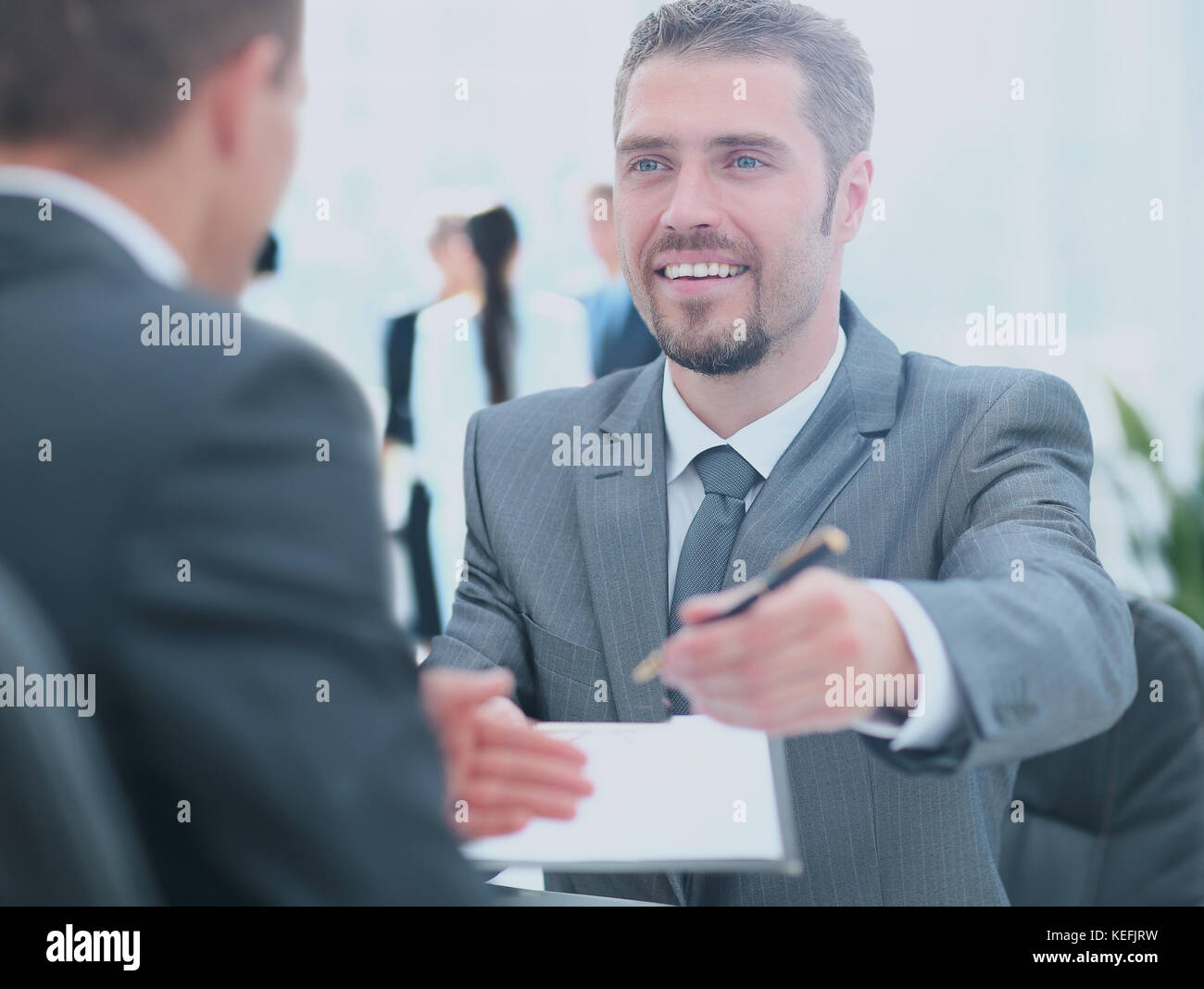 Businessman giving a pen his customer Stock Photo - Alamy