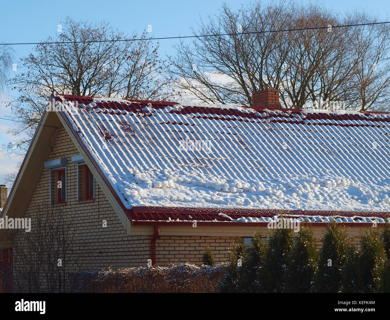 Red color snowy metal roof with snow barrier Stock Photo - Alamy