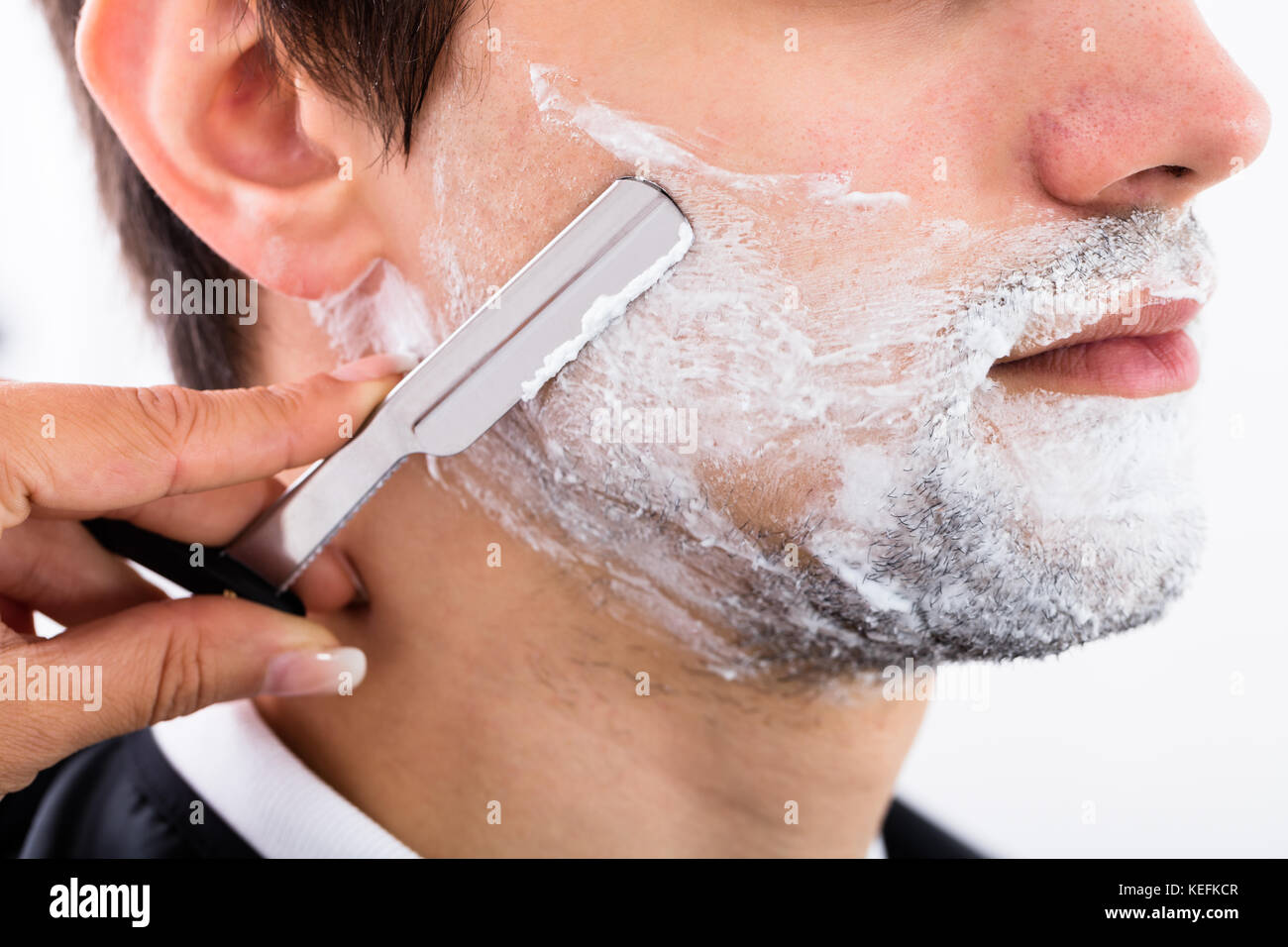 Close-up Of A Hairdresser Shaving Man's Beard By Applying Shaving Cream ...