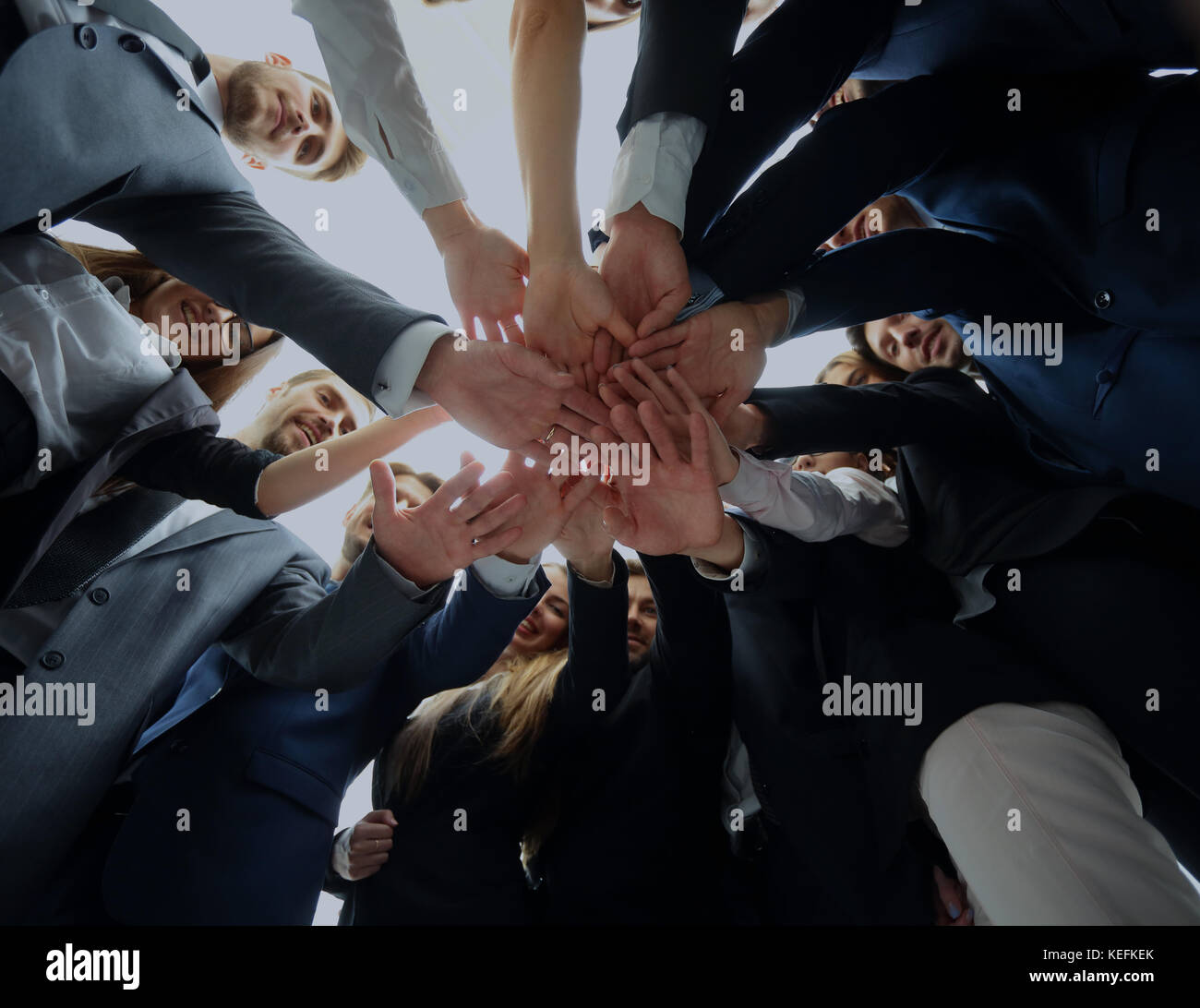 Large business team showing unity with their hands together Stock Photo - Alamy