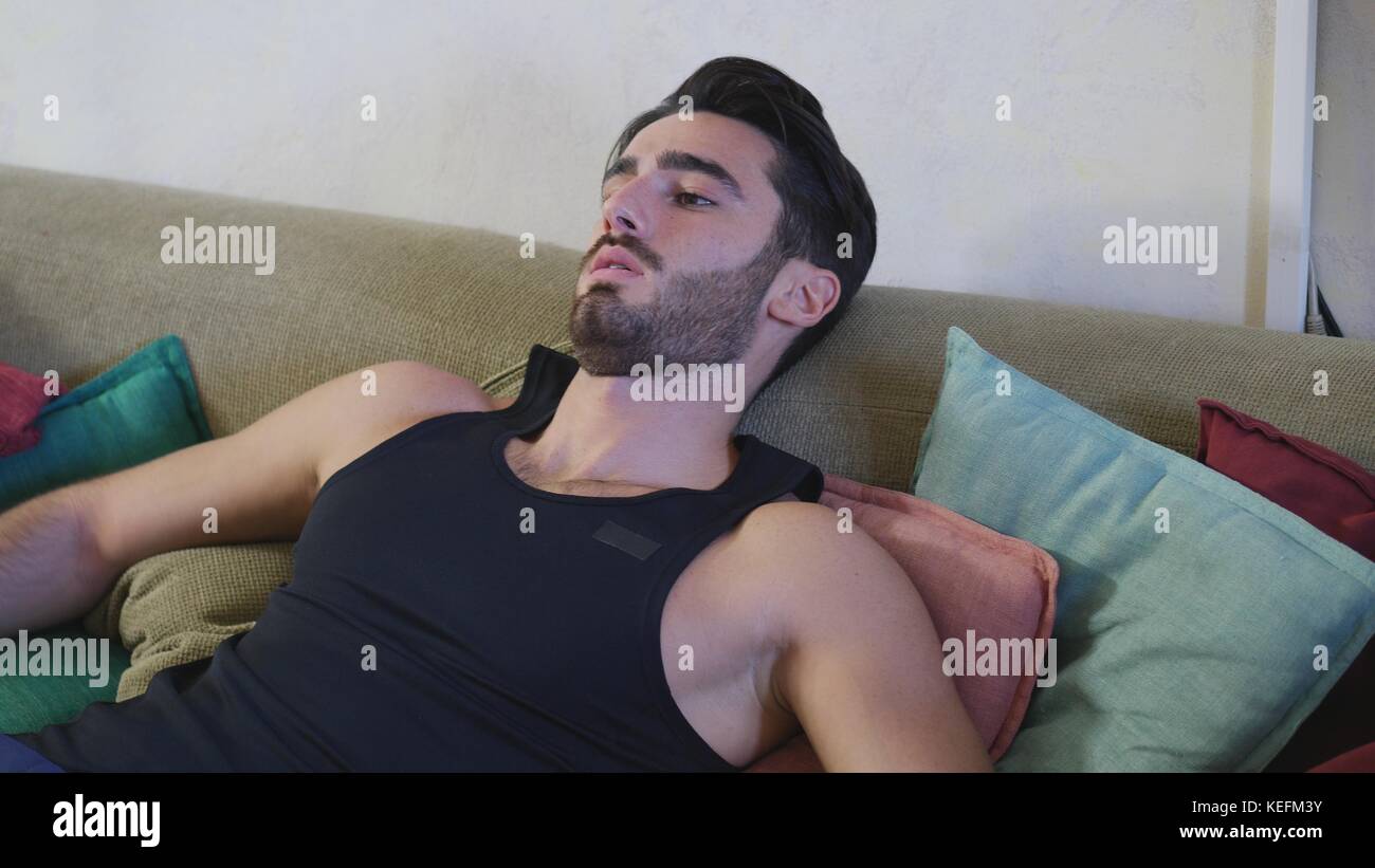 Three Quarter Shot of a Young Man Resting on the Couch in the Home ...