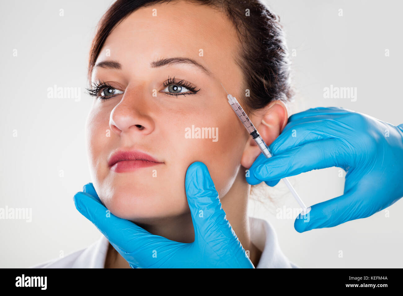 Close-up Of A Person's Hand Injecting Syringe On Young Woman's Face ...