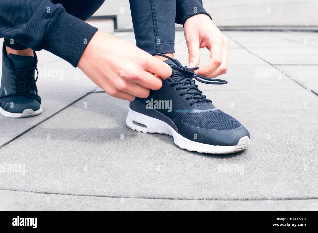 MODEL RELEASED. Woman tying trainers Stock Photo - Alamy