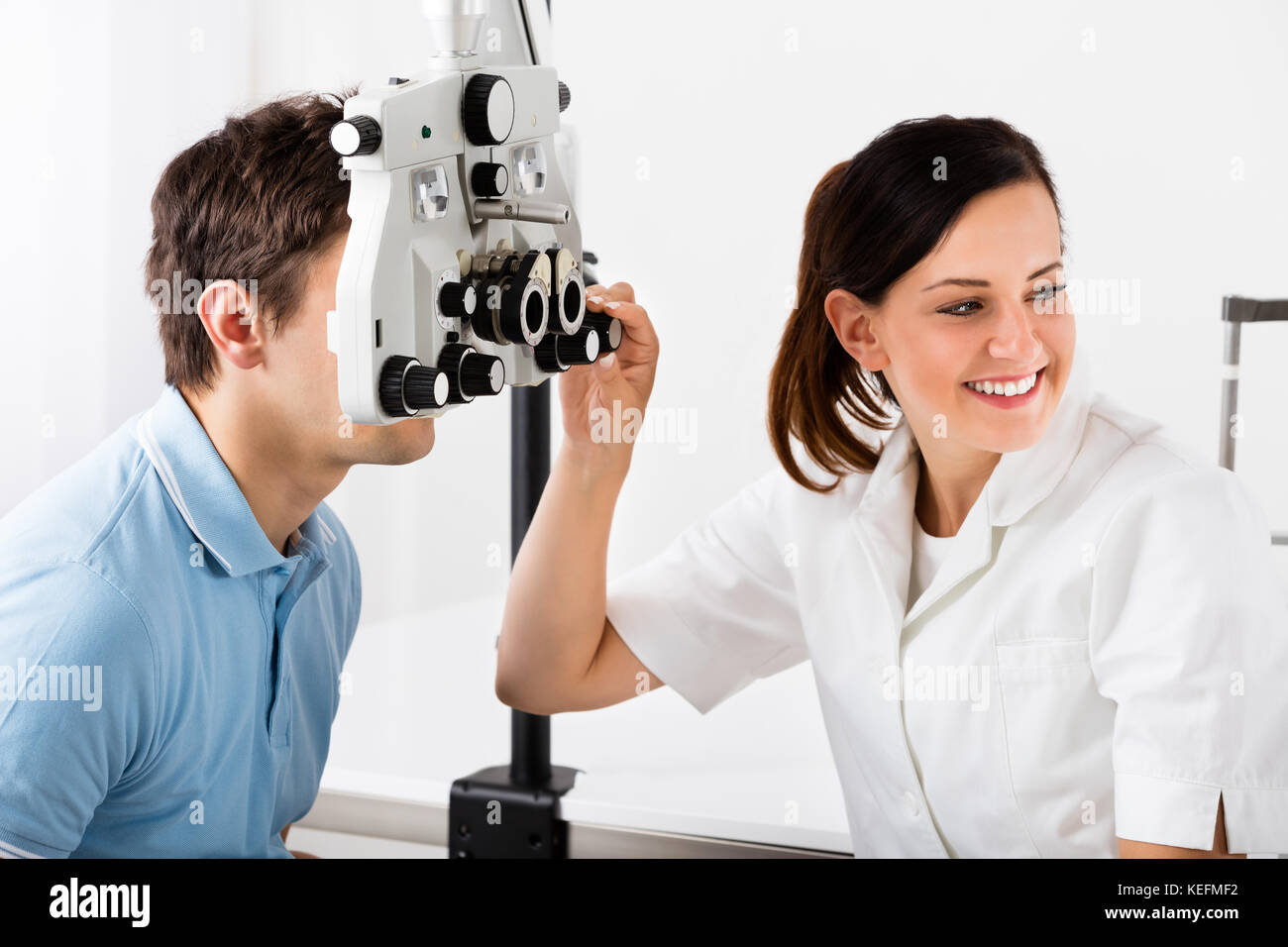 Happy Female Optometrist Doing Sight Testing For Male Patient In Clinic ...
