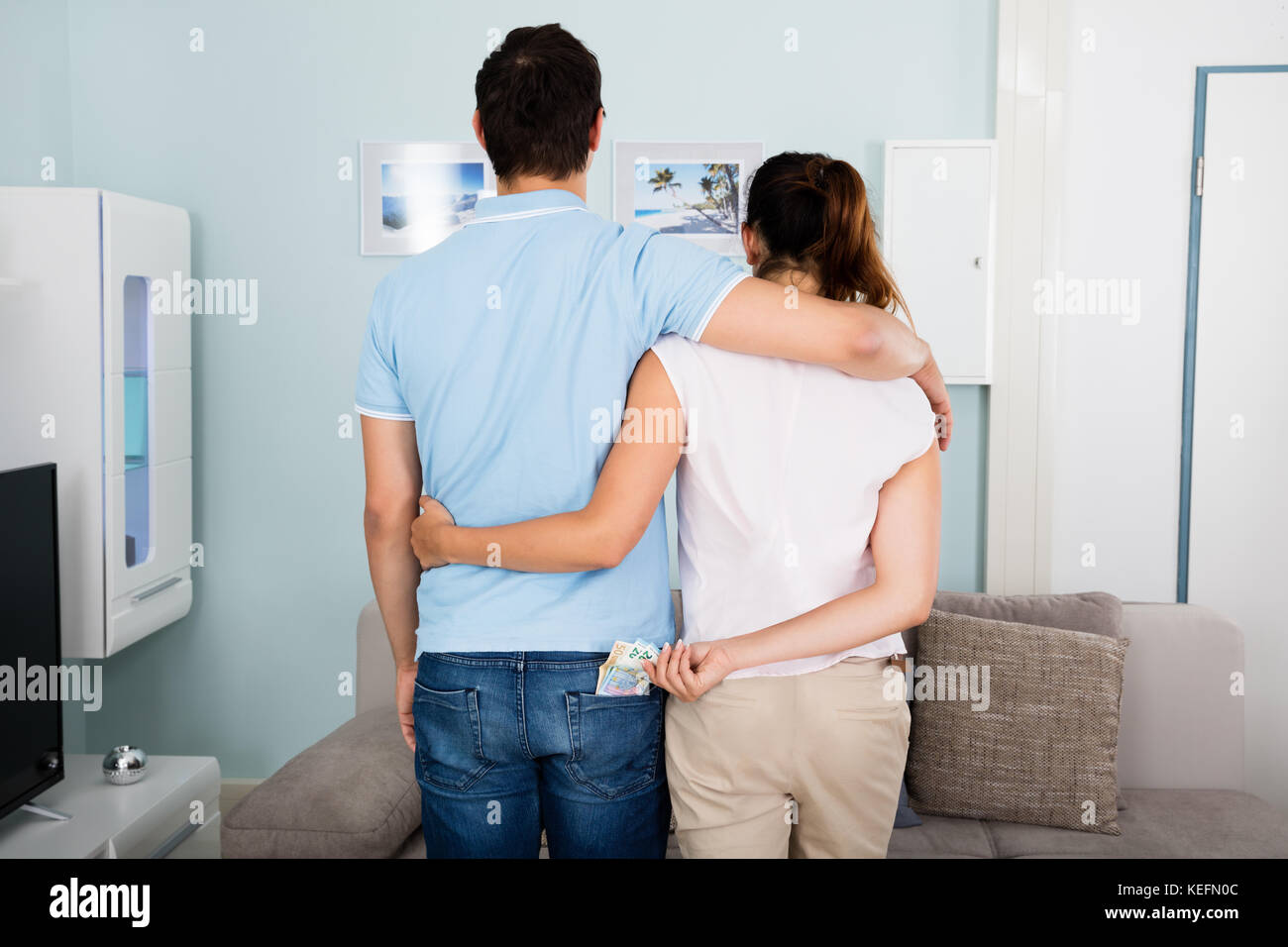 Rear View Of Woman Stealing Money From Husband's Pocket Without ...