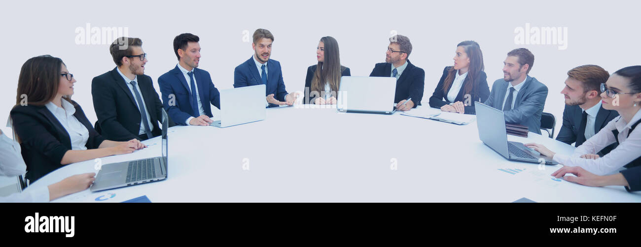 close-up of a large round table on which are working papers and ...