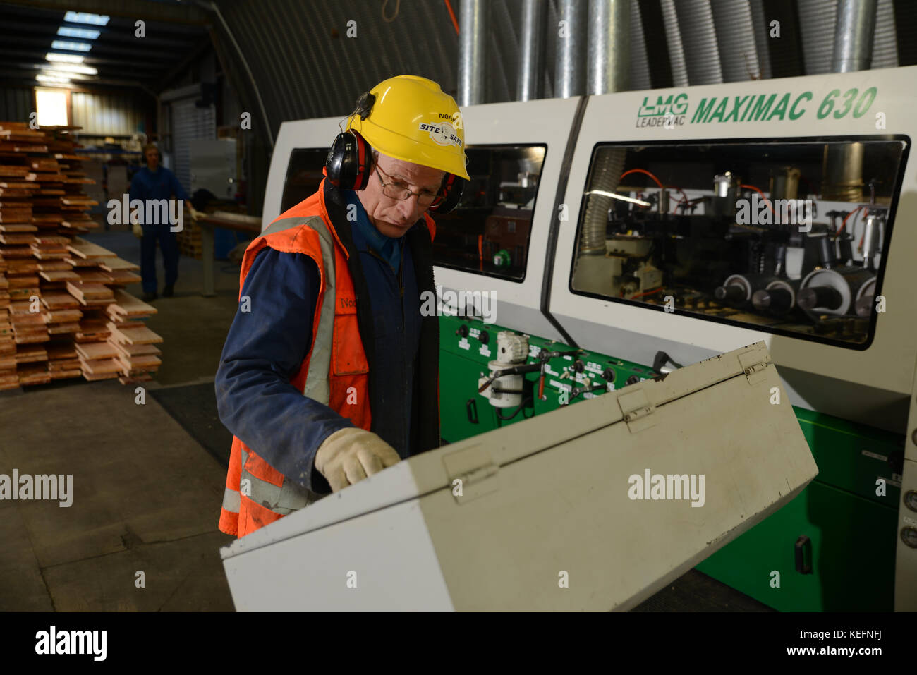 Workers use a four sider machine to plane rough edges from four sides ...