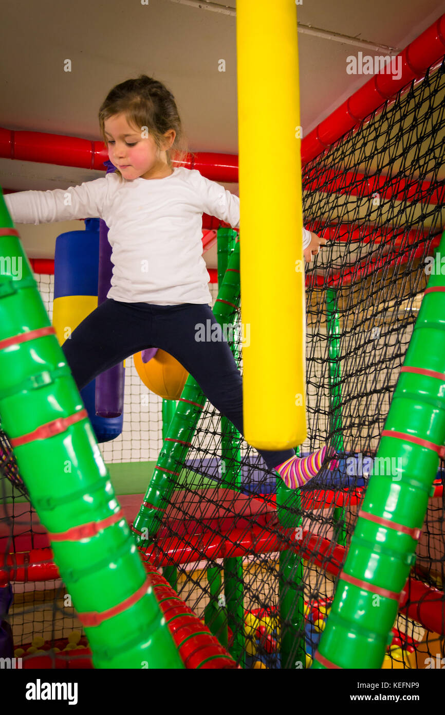 Little girl plays climbing in an indoor playground Stock Photo - Alamy