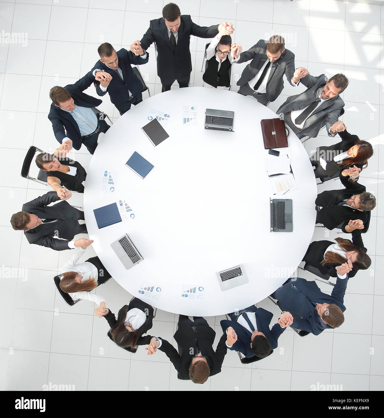 large business team sitting at the round table and raising his hands up ...
