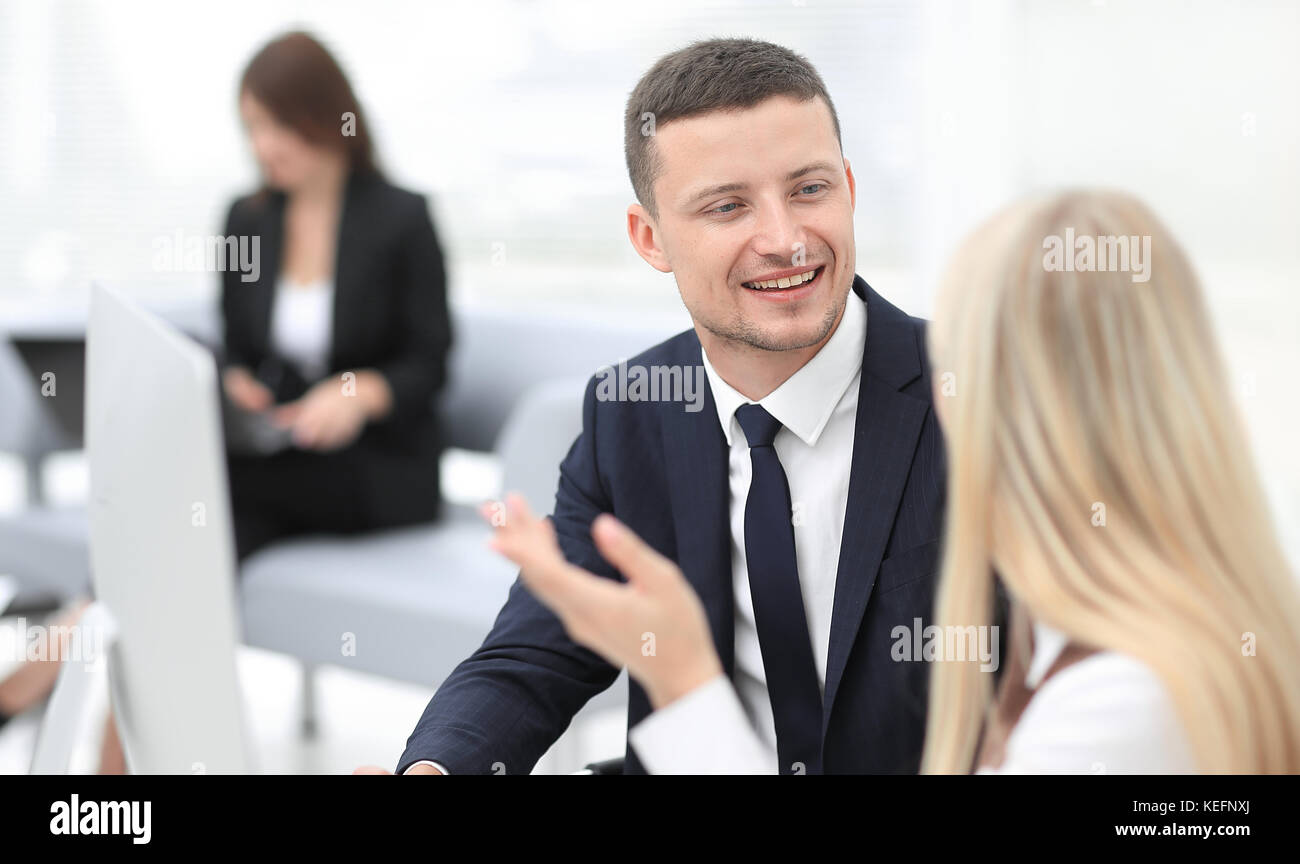 Manager talking with a colleague at the workplace Stock Photo - Alamy