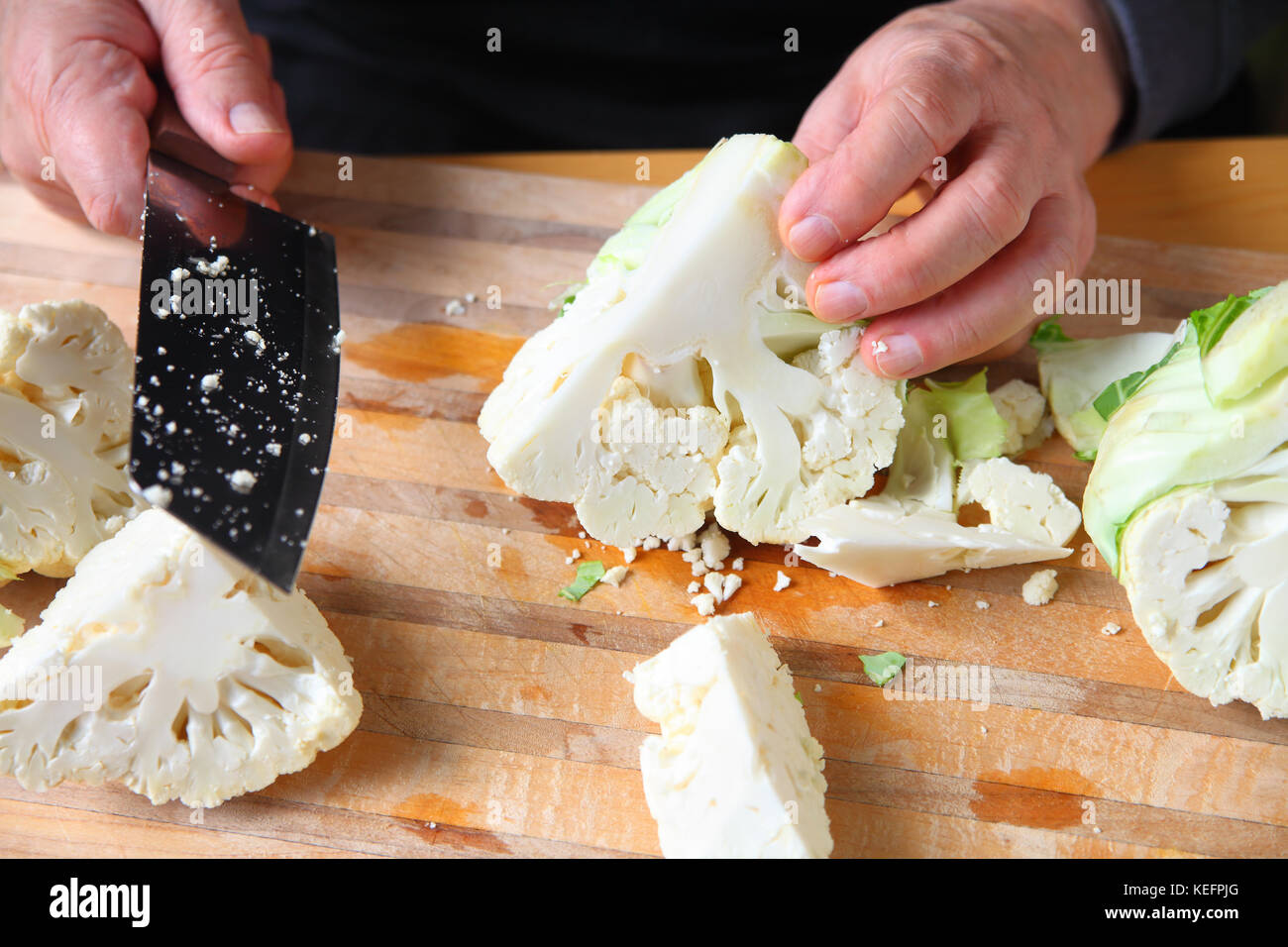 A man cuts up a cauliflower on a chopping board Stock Photo - Alamy