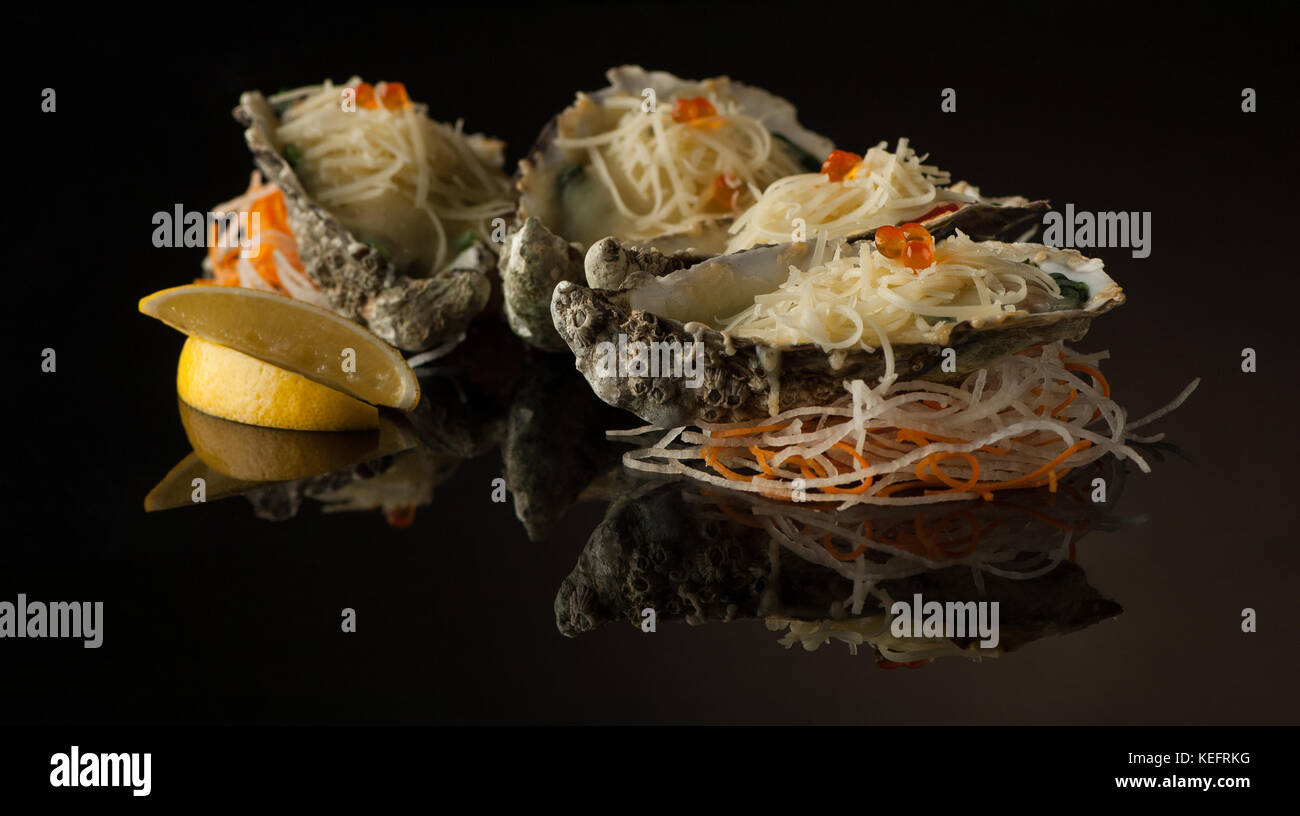 seafood and mussels in a shell with melted cheese and lemon slices on a ...