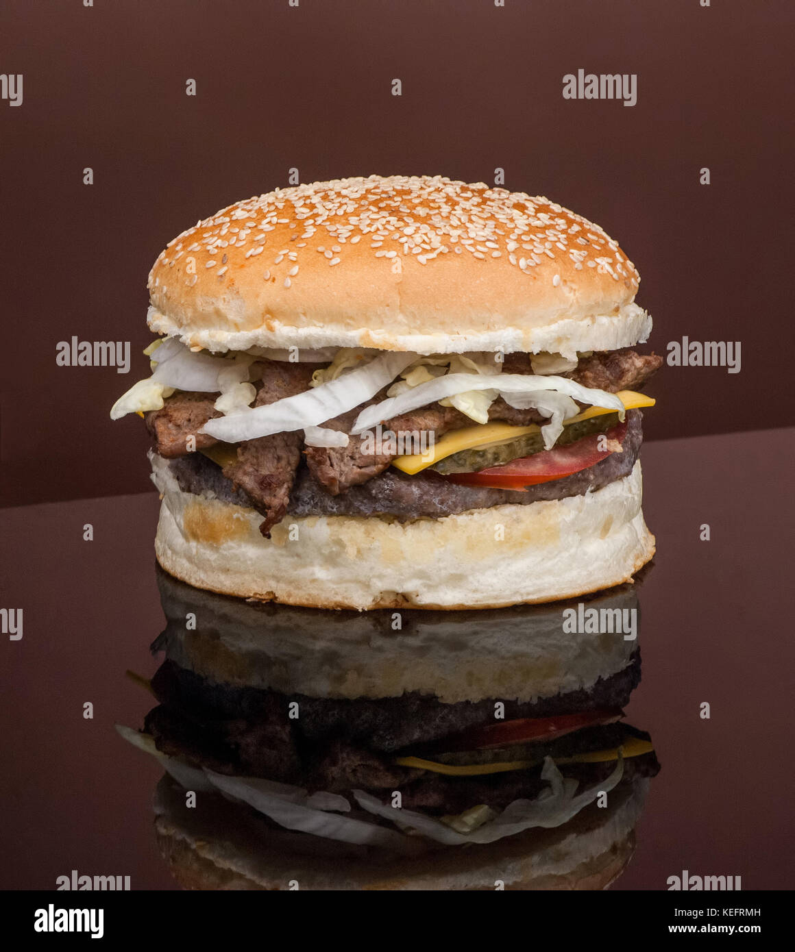 cheeseburger with cutlet and meat on a dark background with reflection ...