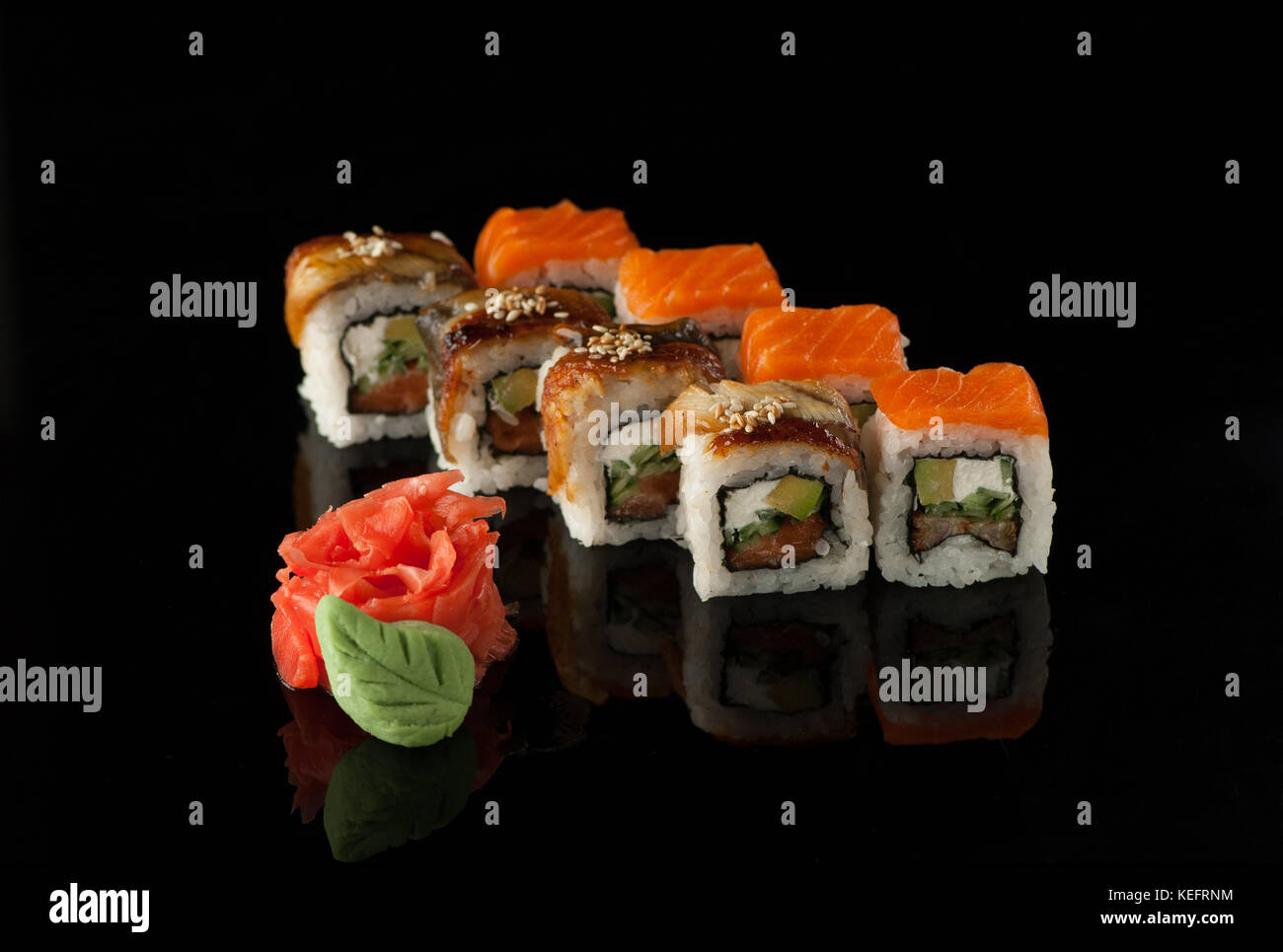 set of sushi cubes with wasabi on a black background with reflection ...