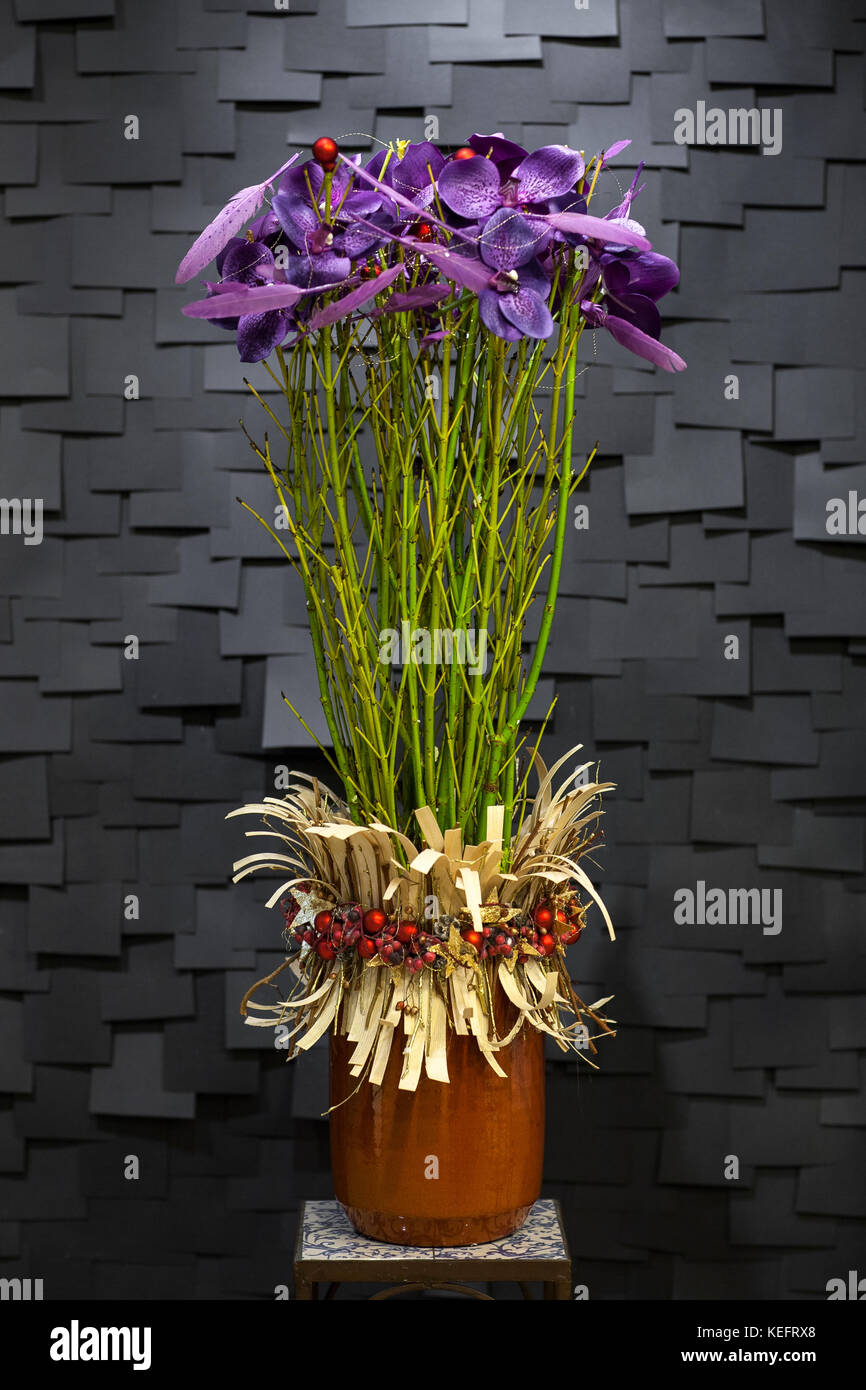 purple flower with a long stem decorations in a pot on a dark ...