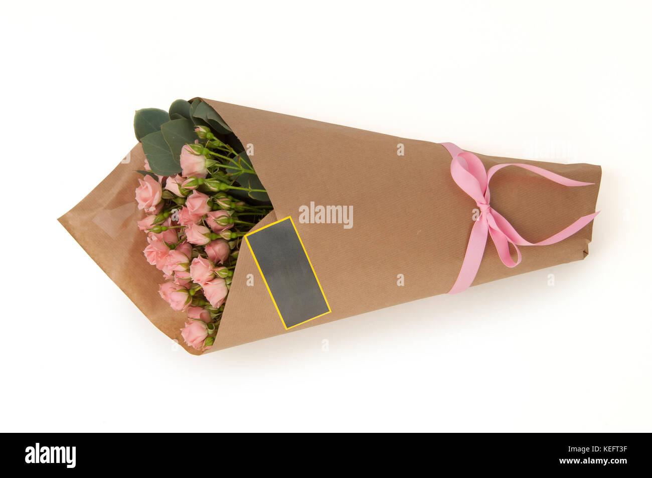 red roses in a paper bouquet tied tape on a white background. Valentine ...