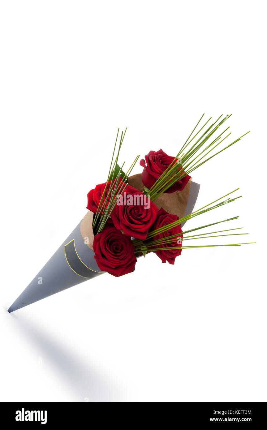 red roses in a bouquet in the shape of cone on a white background ...